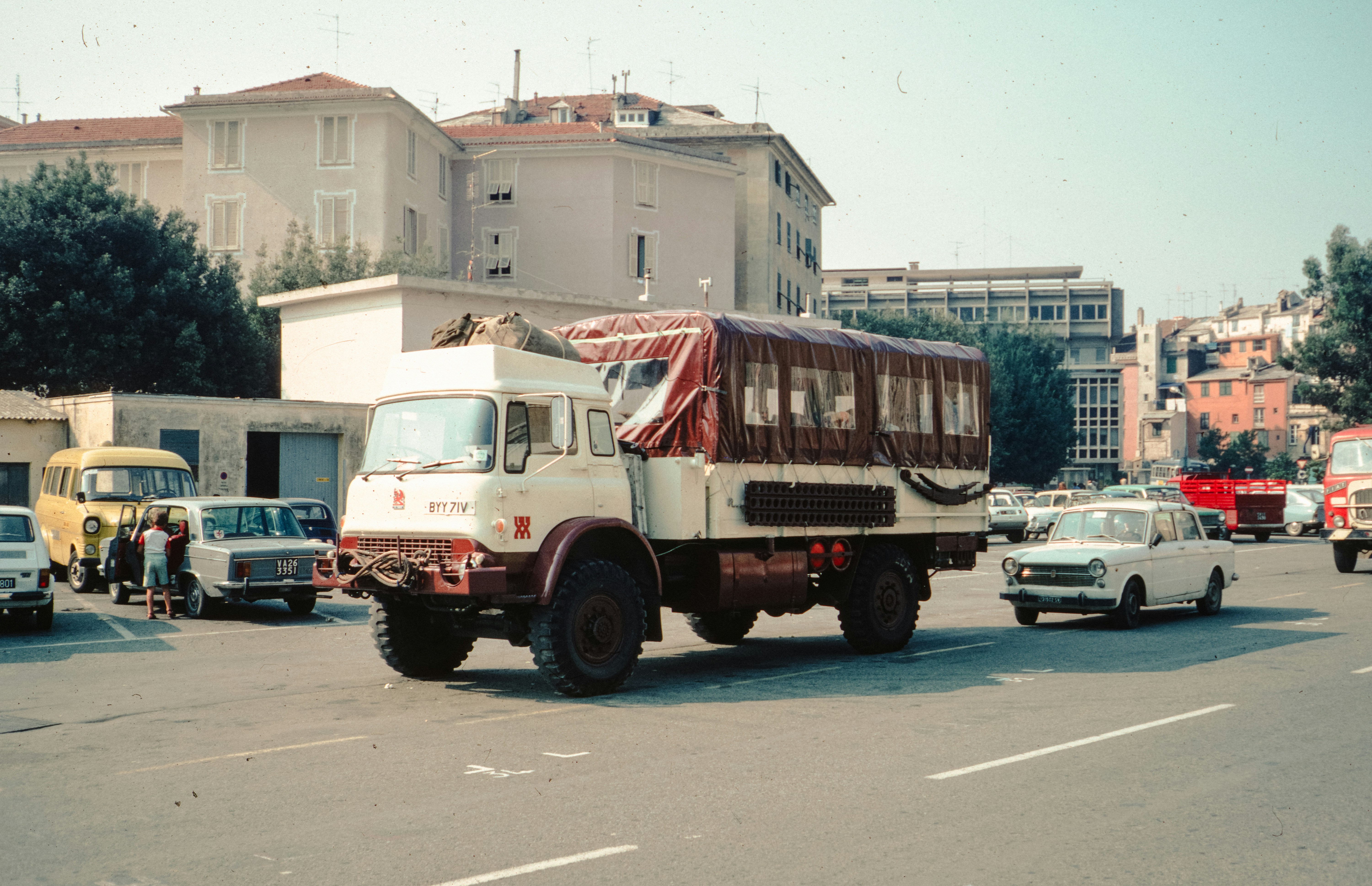Midday Parade: A Weathered Truck Reigns Over a Busy City Square