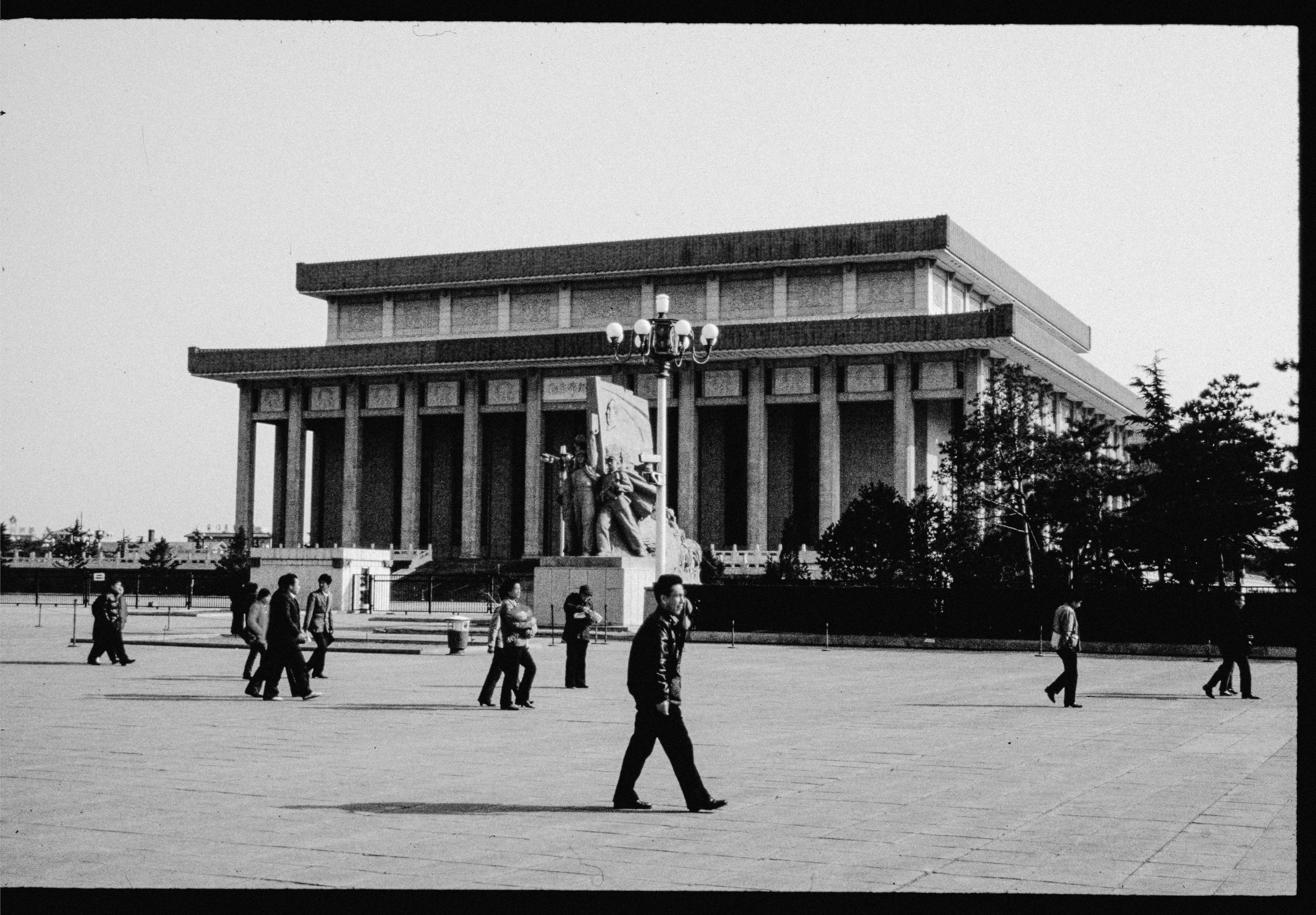 Plaza Visitors and Monument: Quiet Movement in Front of a Classical Building