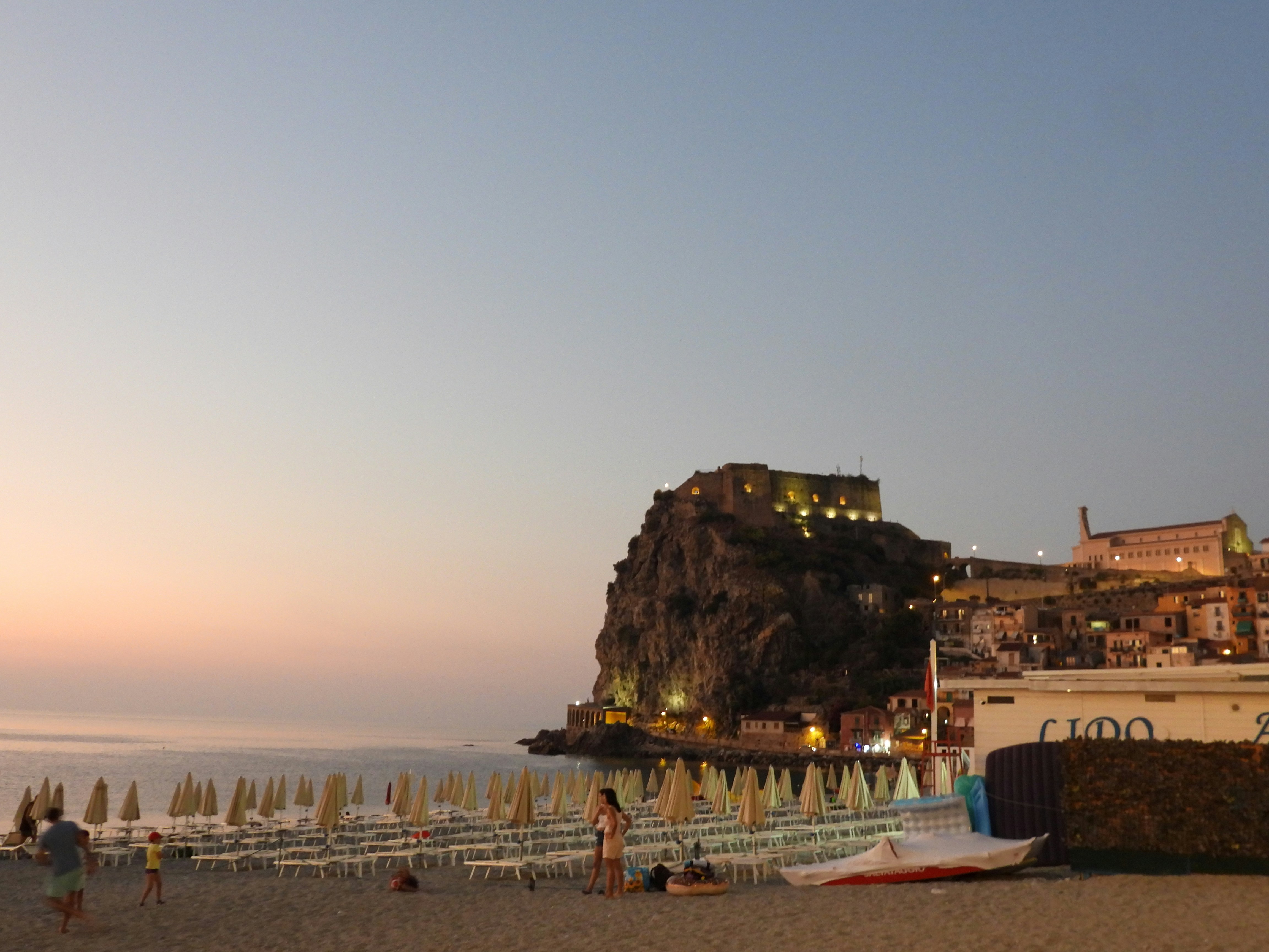 Sunset on the Cliffside Village: A Coastal Scene with Beachfront Calm