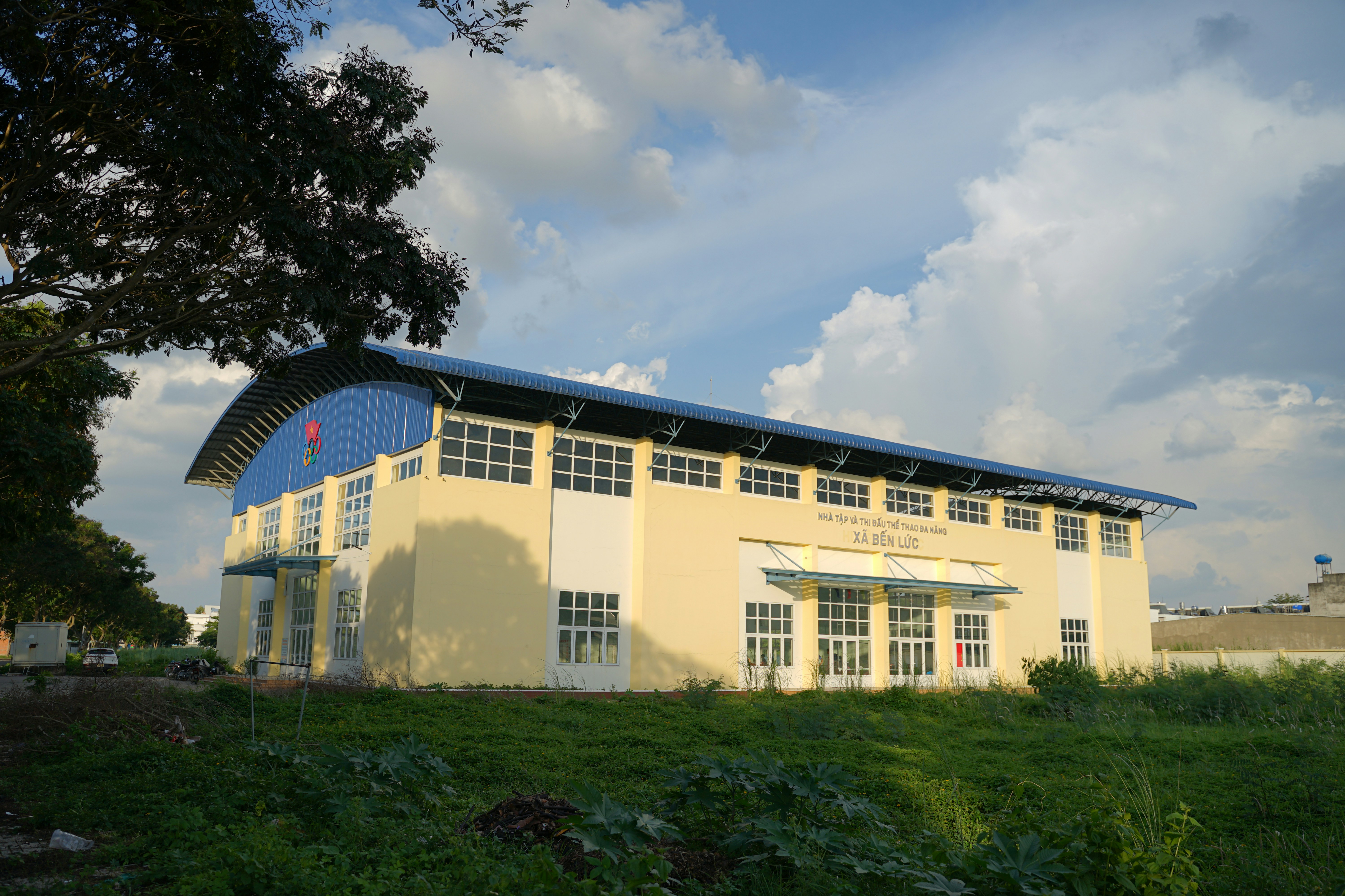 Sunlit Campus Hall Rising from the Green Field