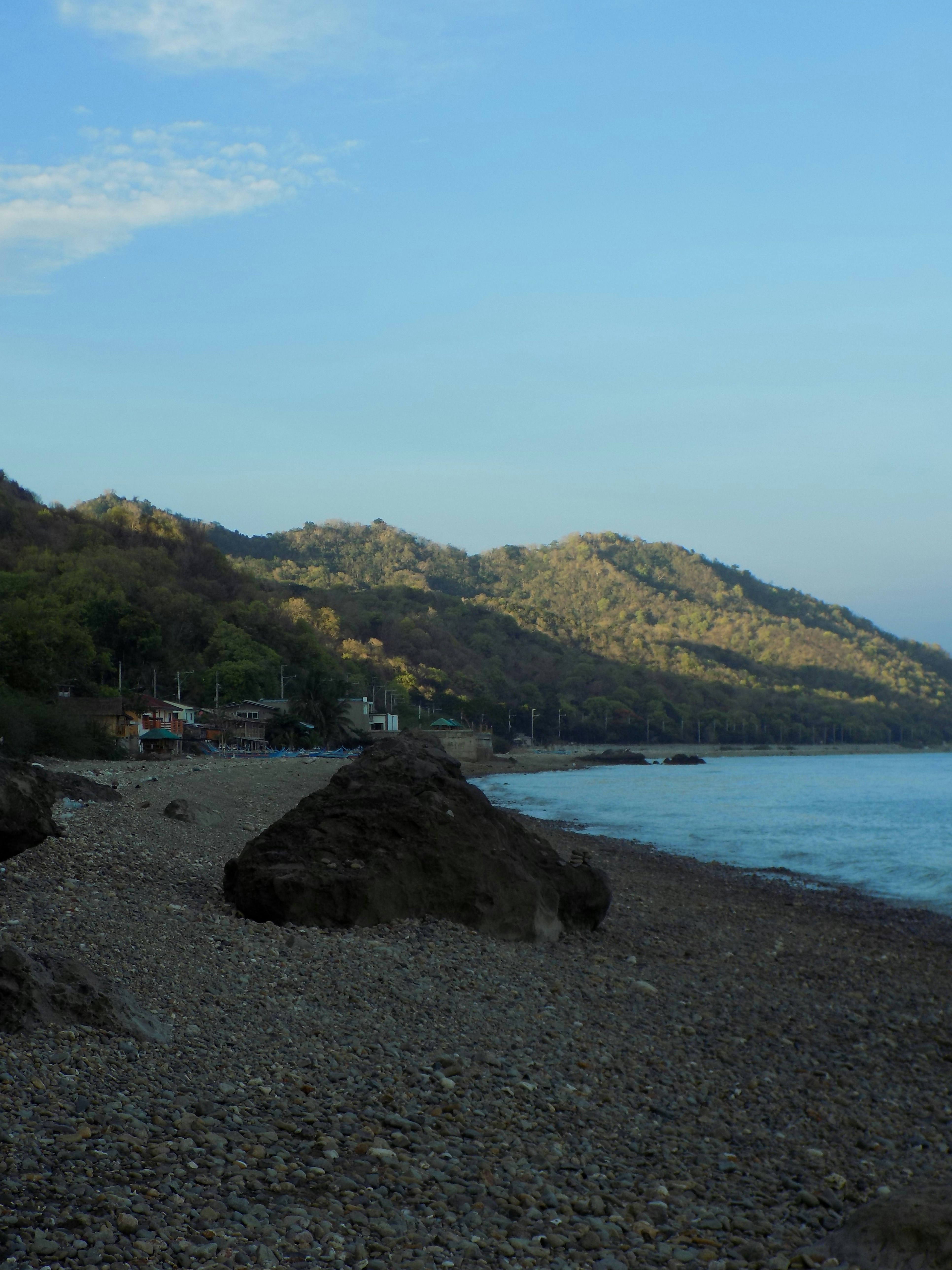 Sunlit Hillside Over a Pebble Beach