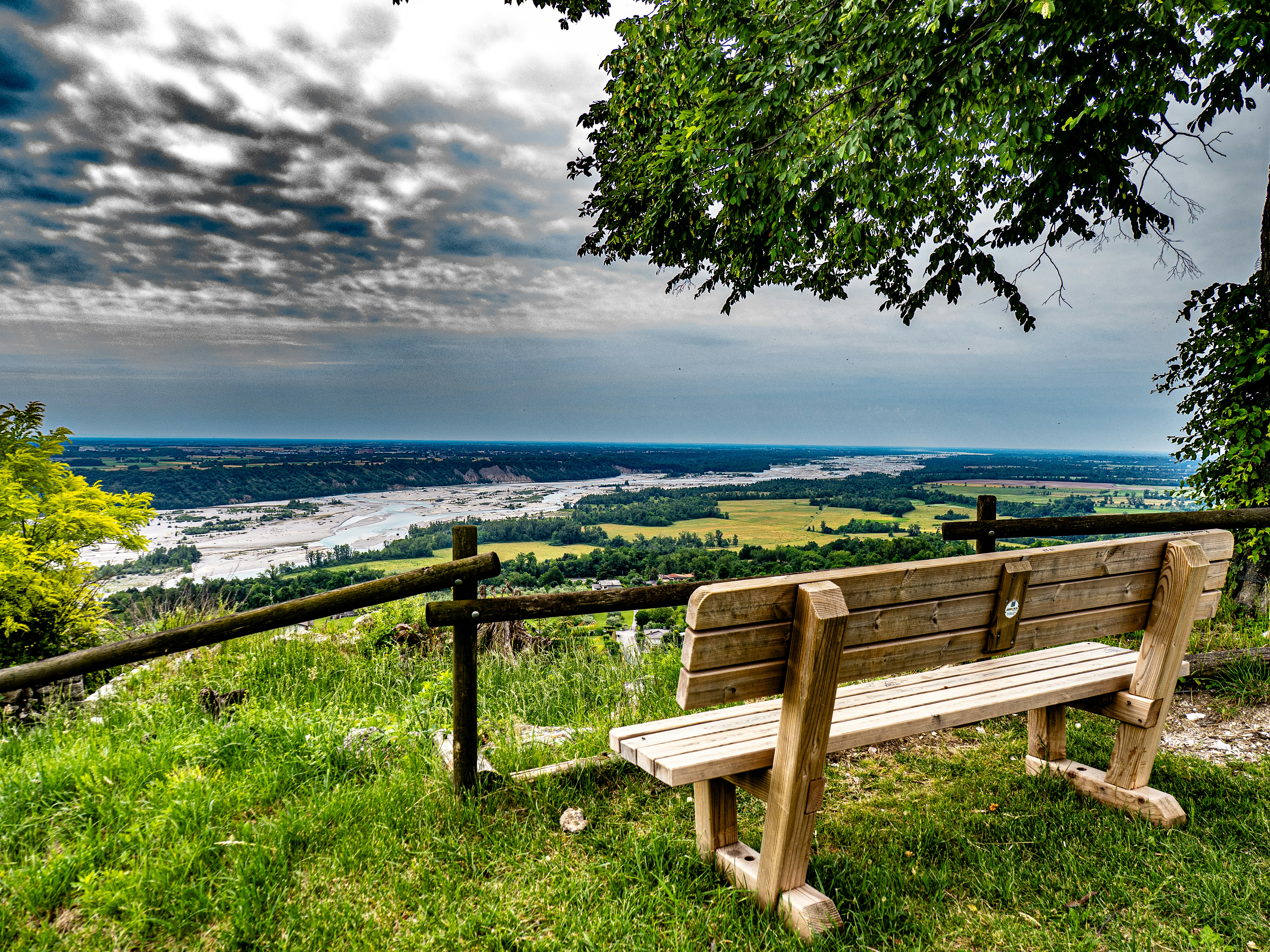 Verdant overlook with weathered bench facing a vast valley