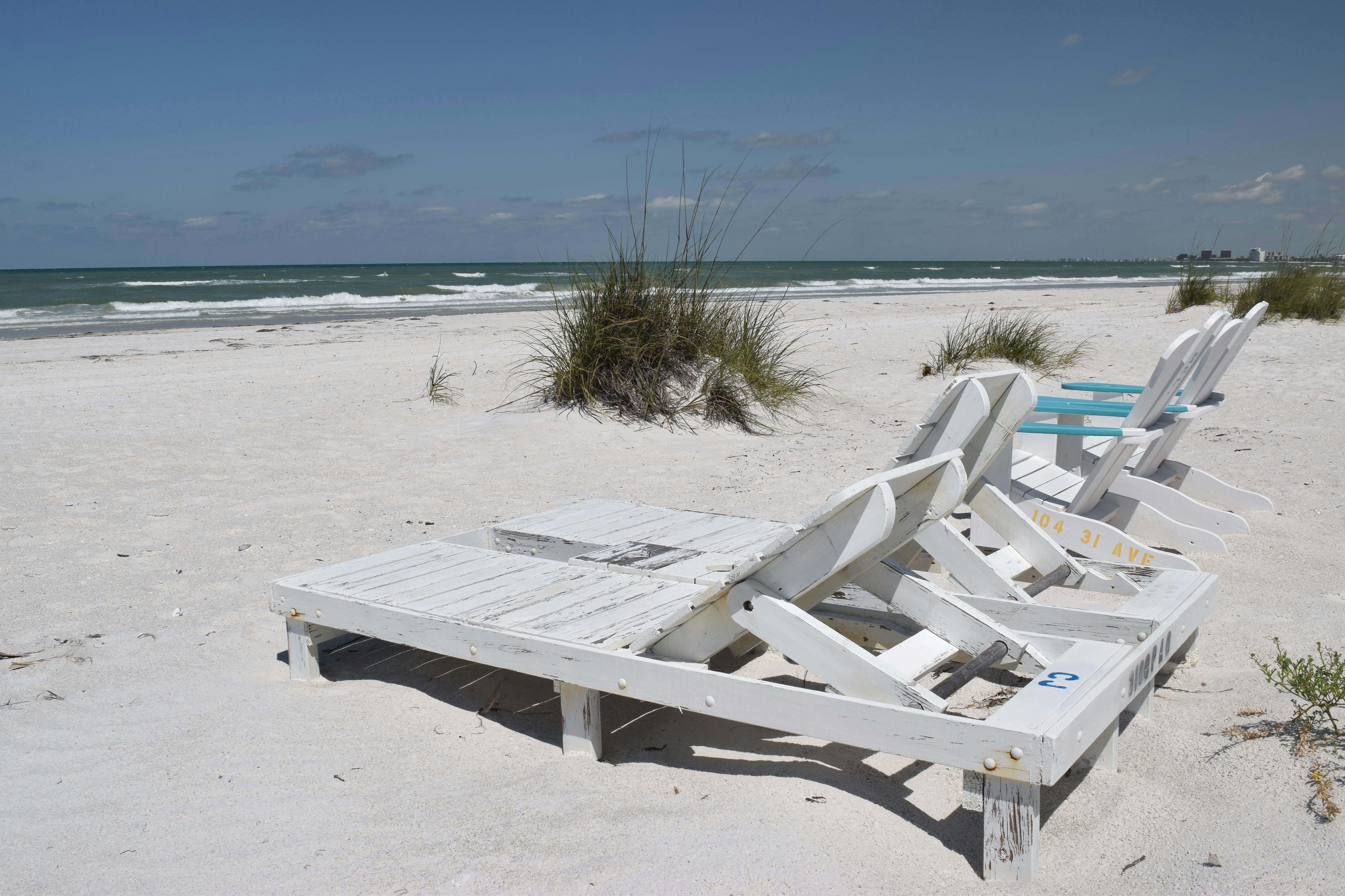 Sun-Swept Lounge: White Deck Chairs on a Quiet Seaside Shore