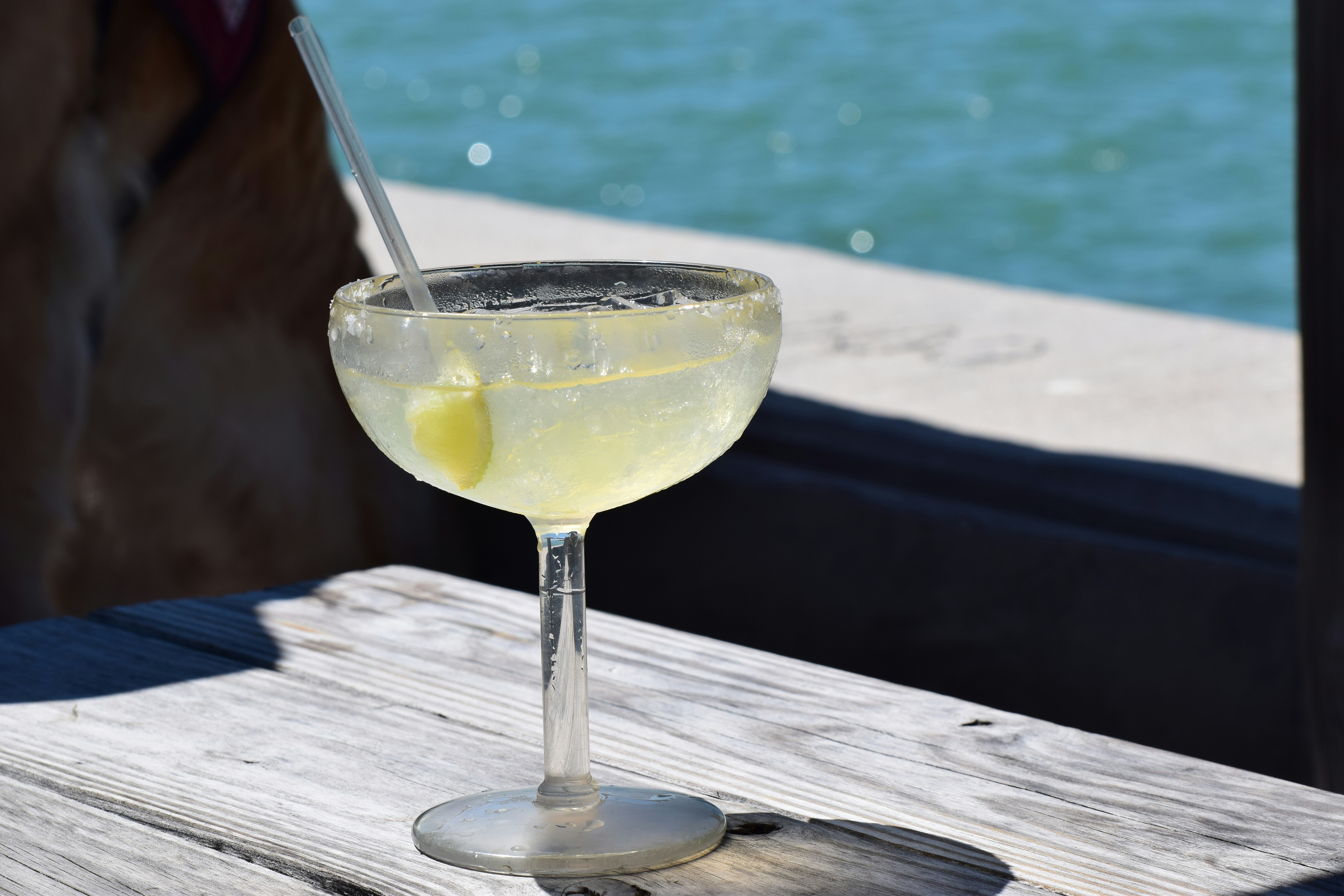 Lemon-touched cocktail at sunlit waterside