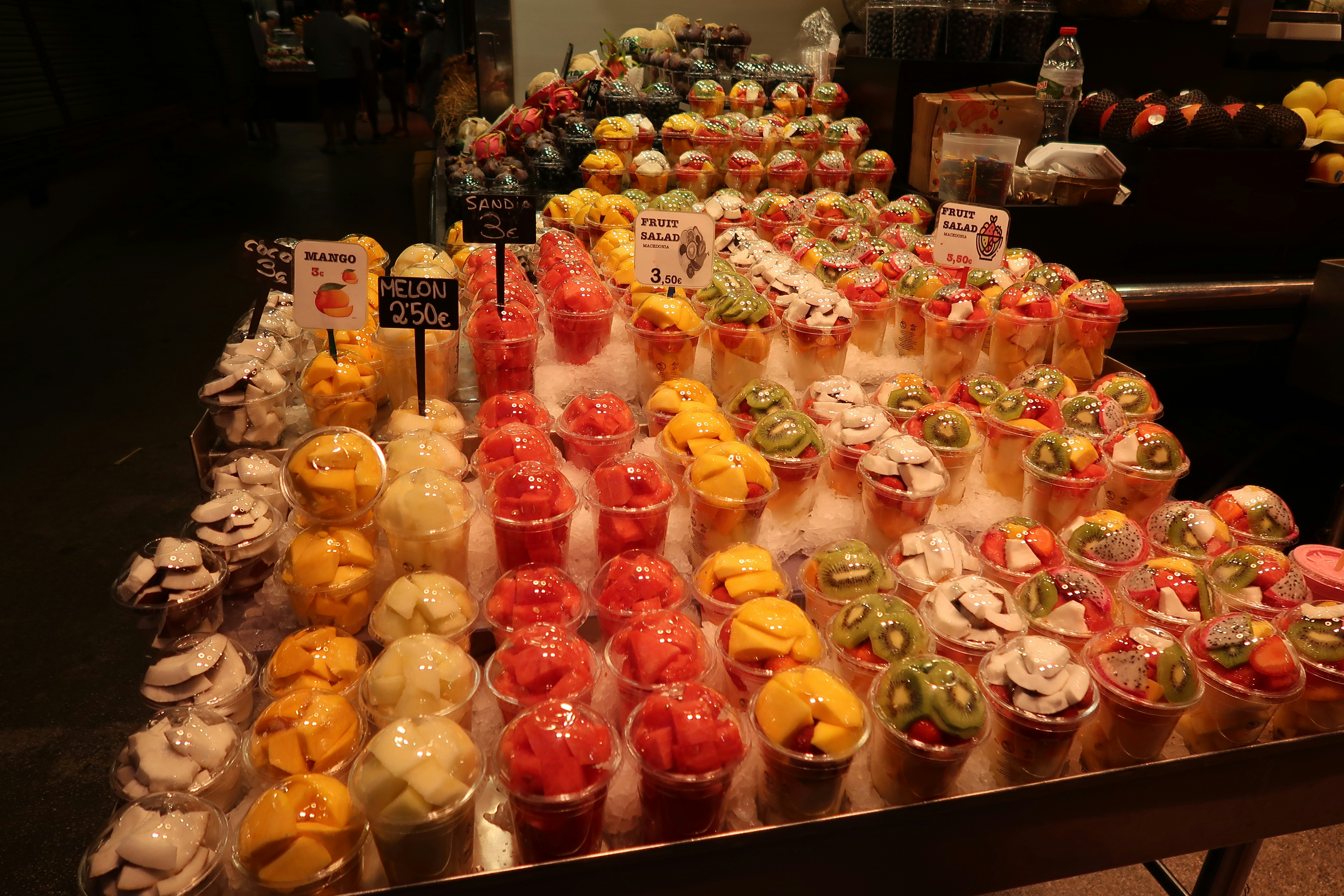 Colorful Dessert Display: Raspberries, Kiwi, and Mango in a Market Stand