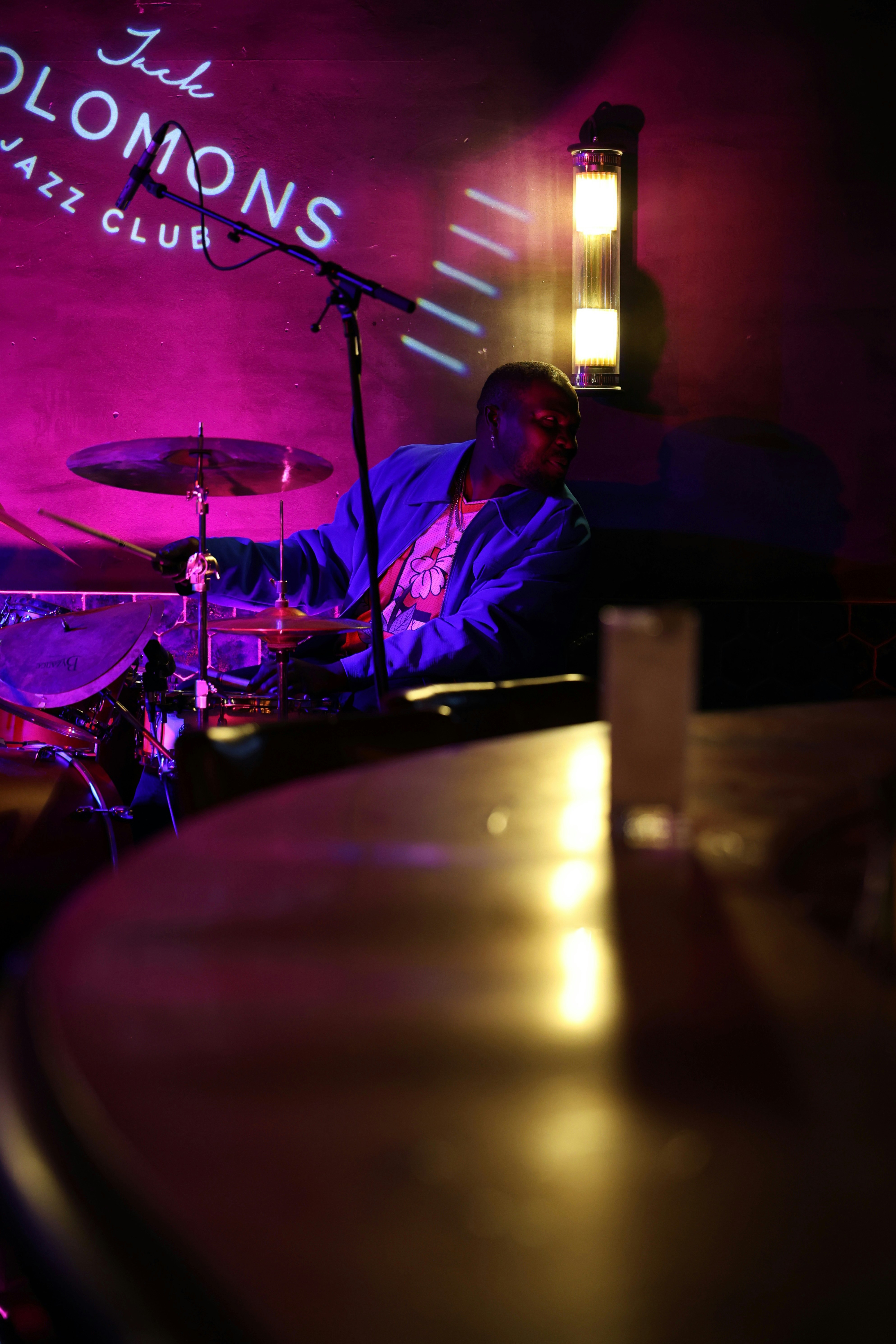 Drummer in neon glow at Jazz Club