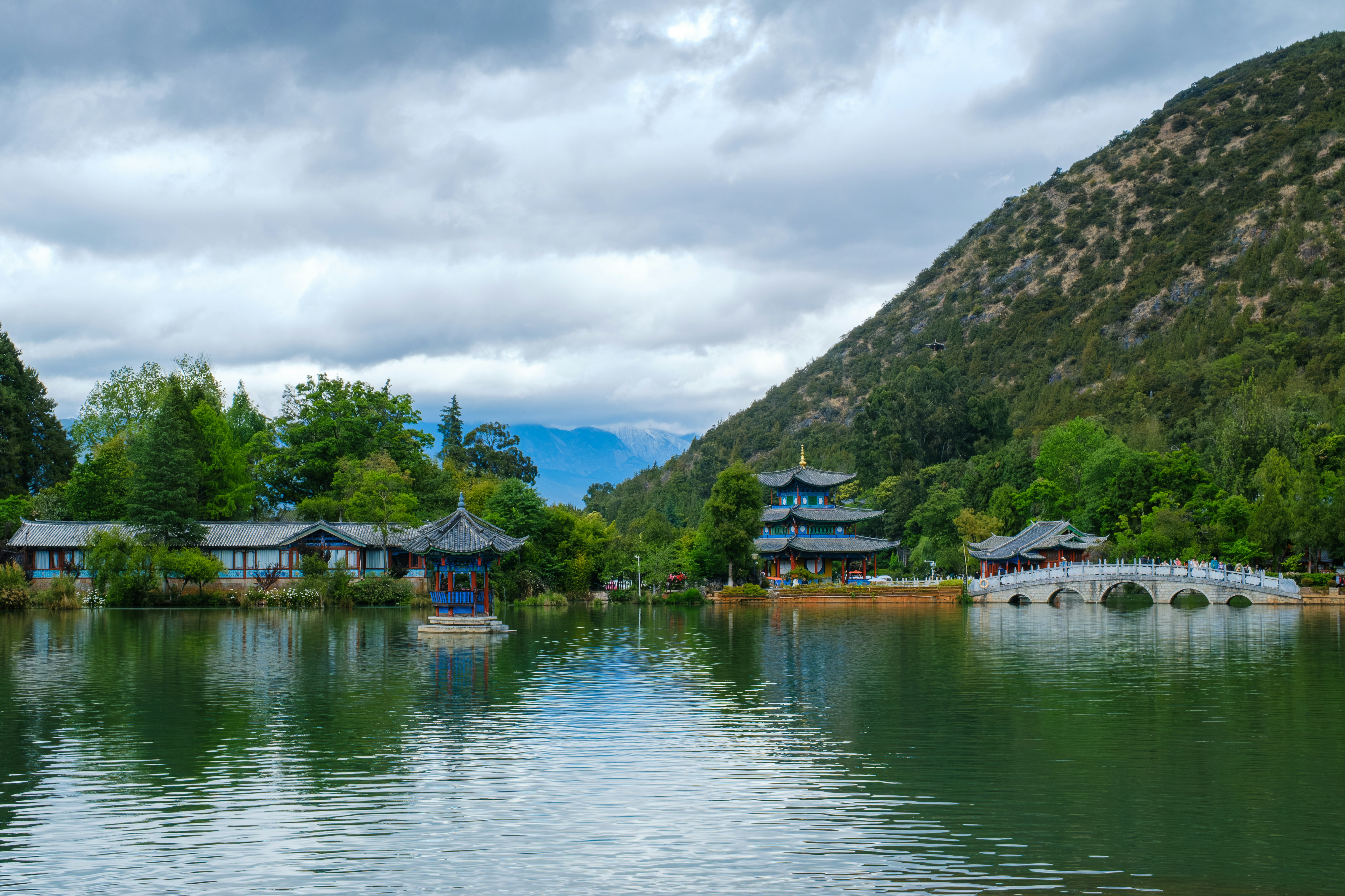 Traditional chinese architecture by a serene lake with a mountain ...