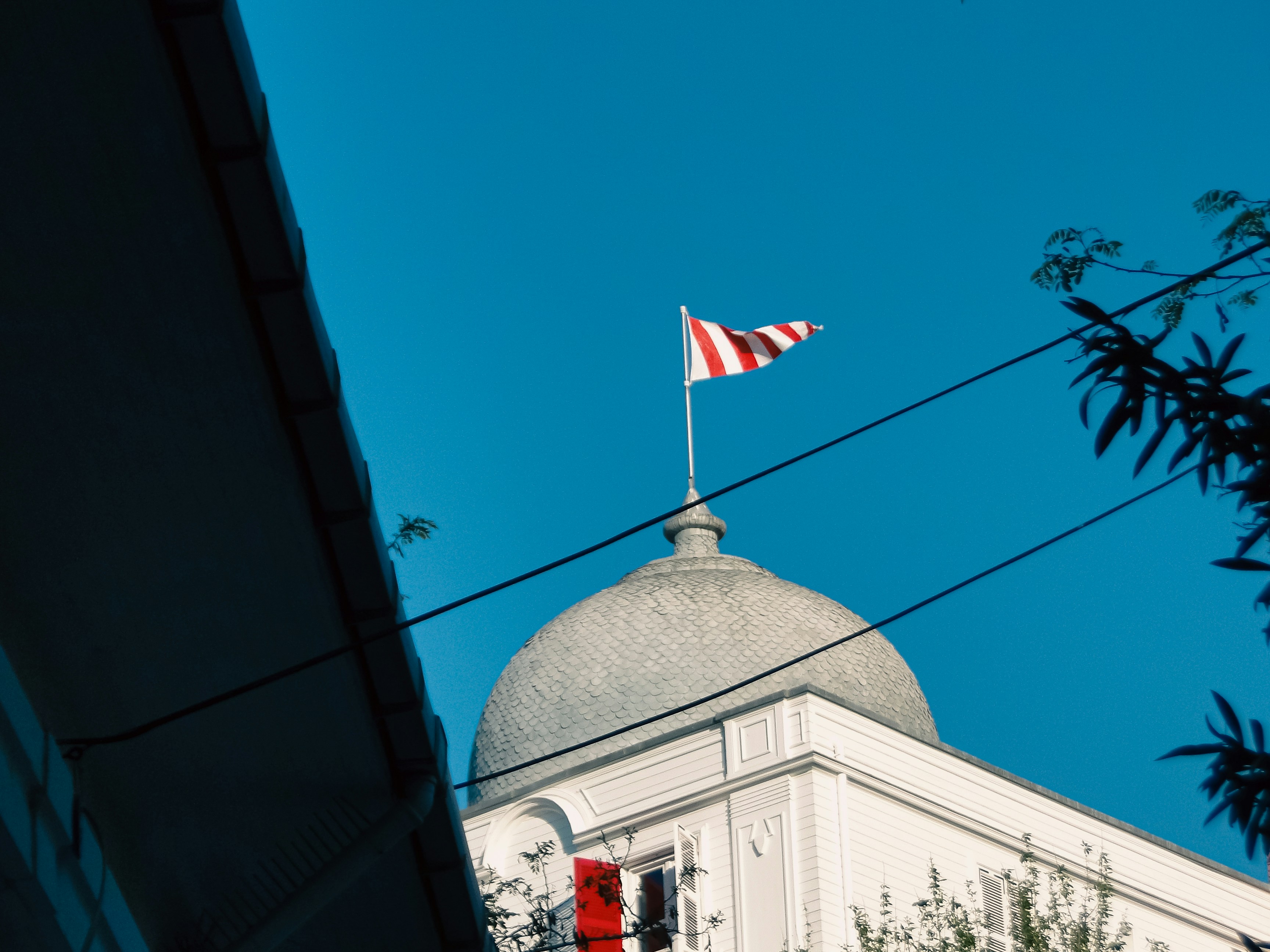 Blue Dome Over Quiet Corner: A City Flag Speaks from the Roofline
