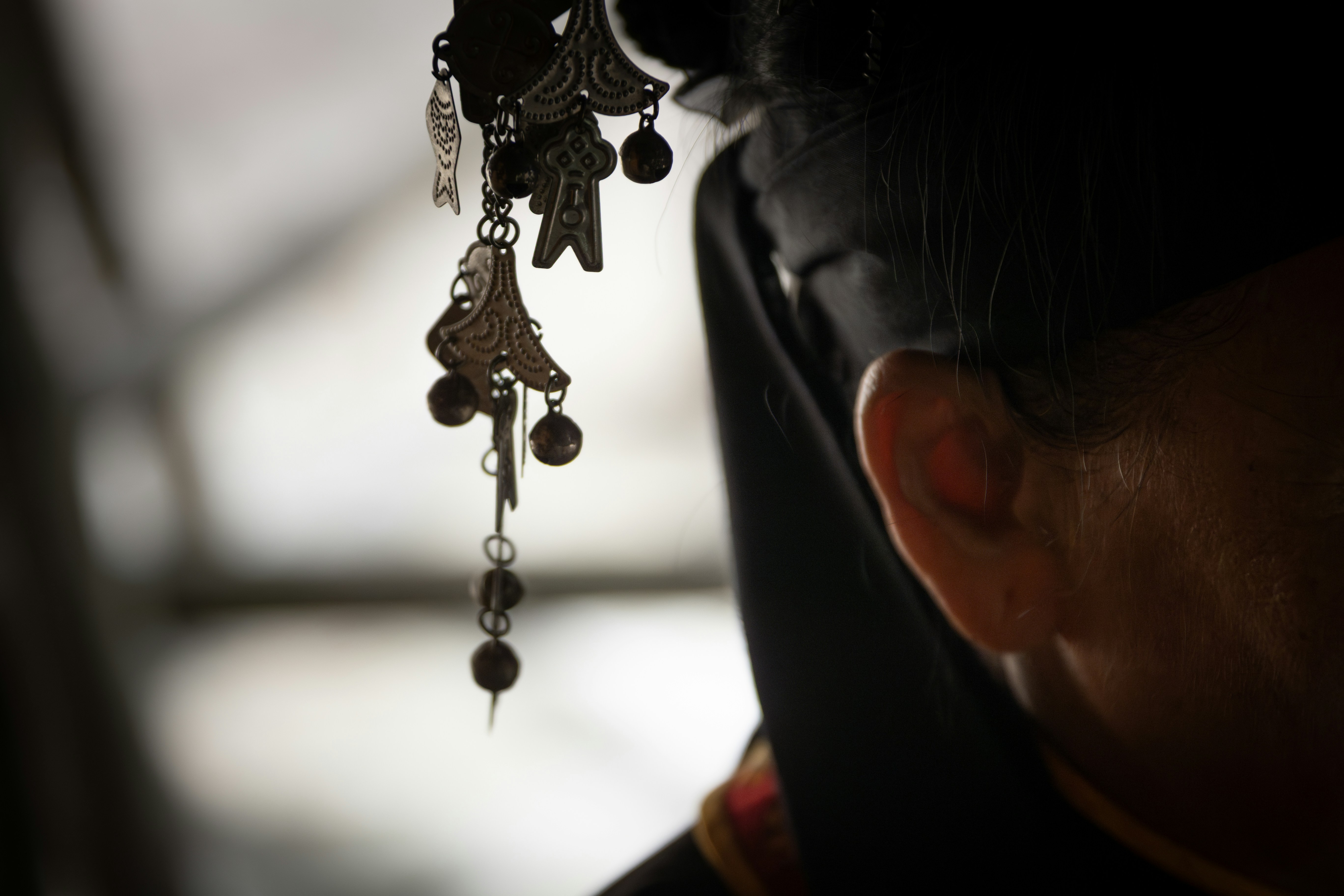 Adornment in focus: subtle jewelry against shadowed veil
