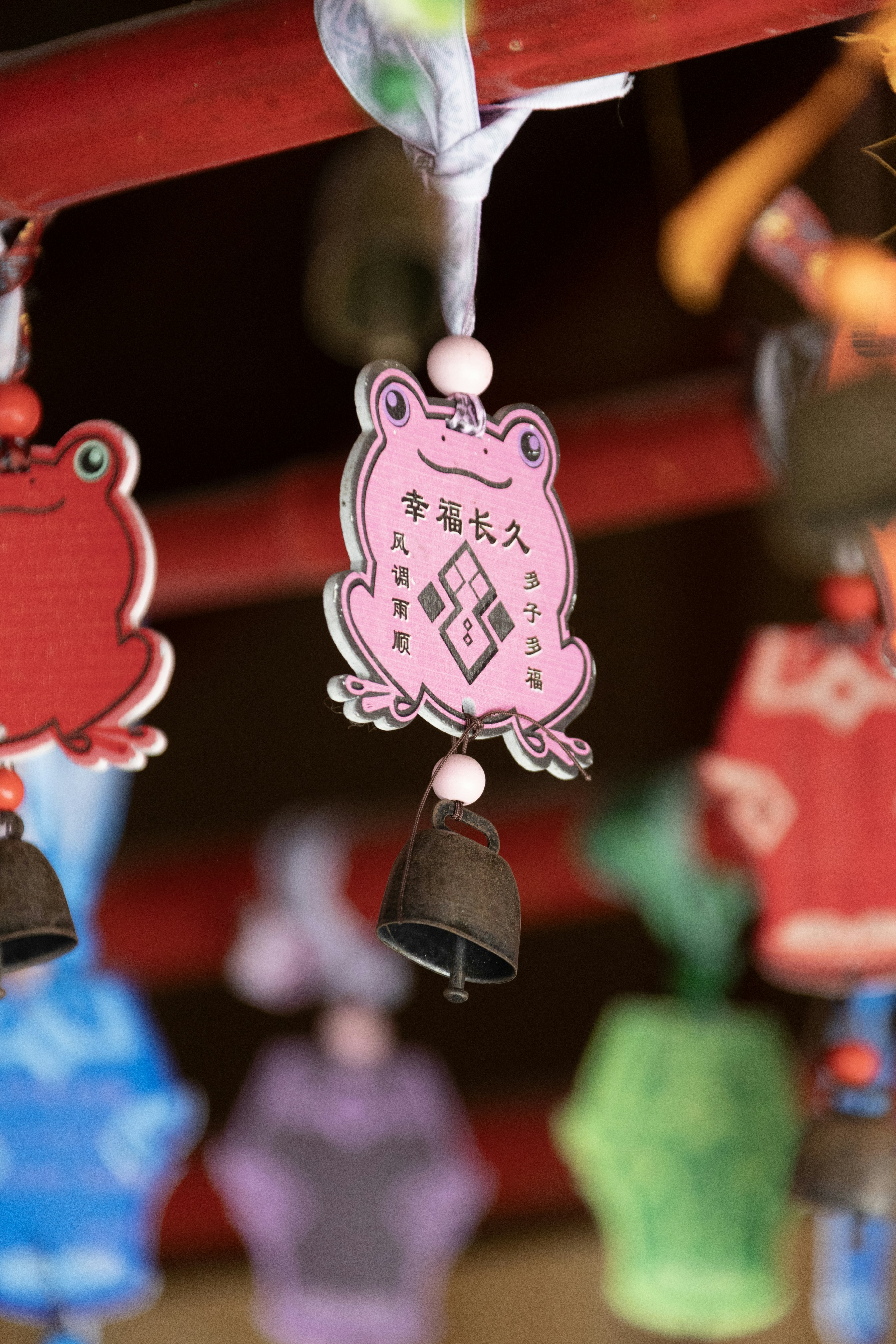 Charm of the Hanging Bell: A Pink Frog Charm in a Colorful Market