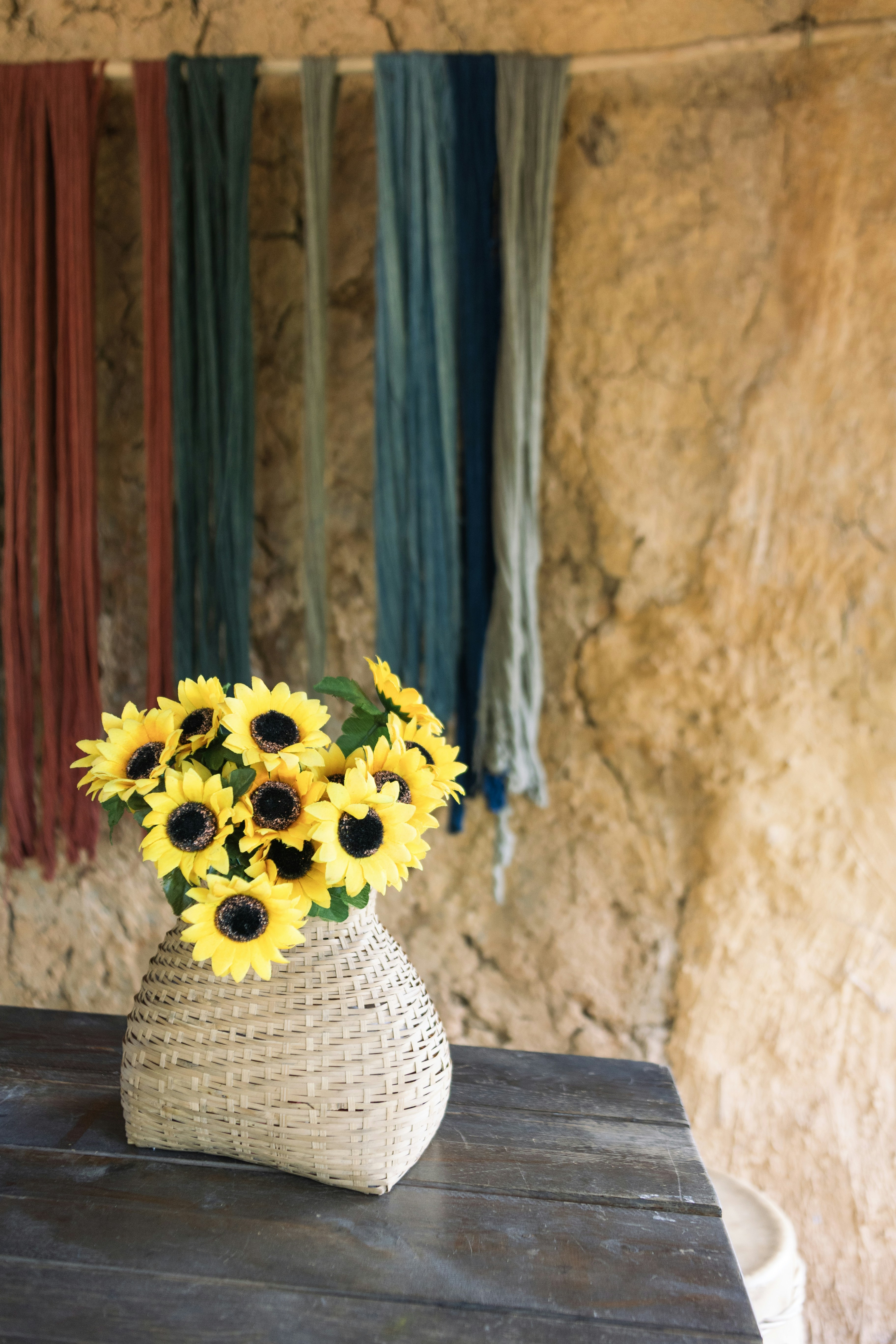 Sunlit Sunflowers in a Woven Vase on a Rustic Table