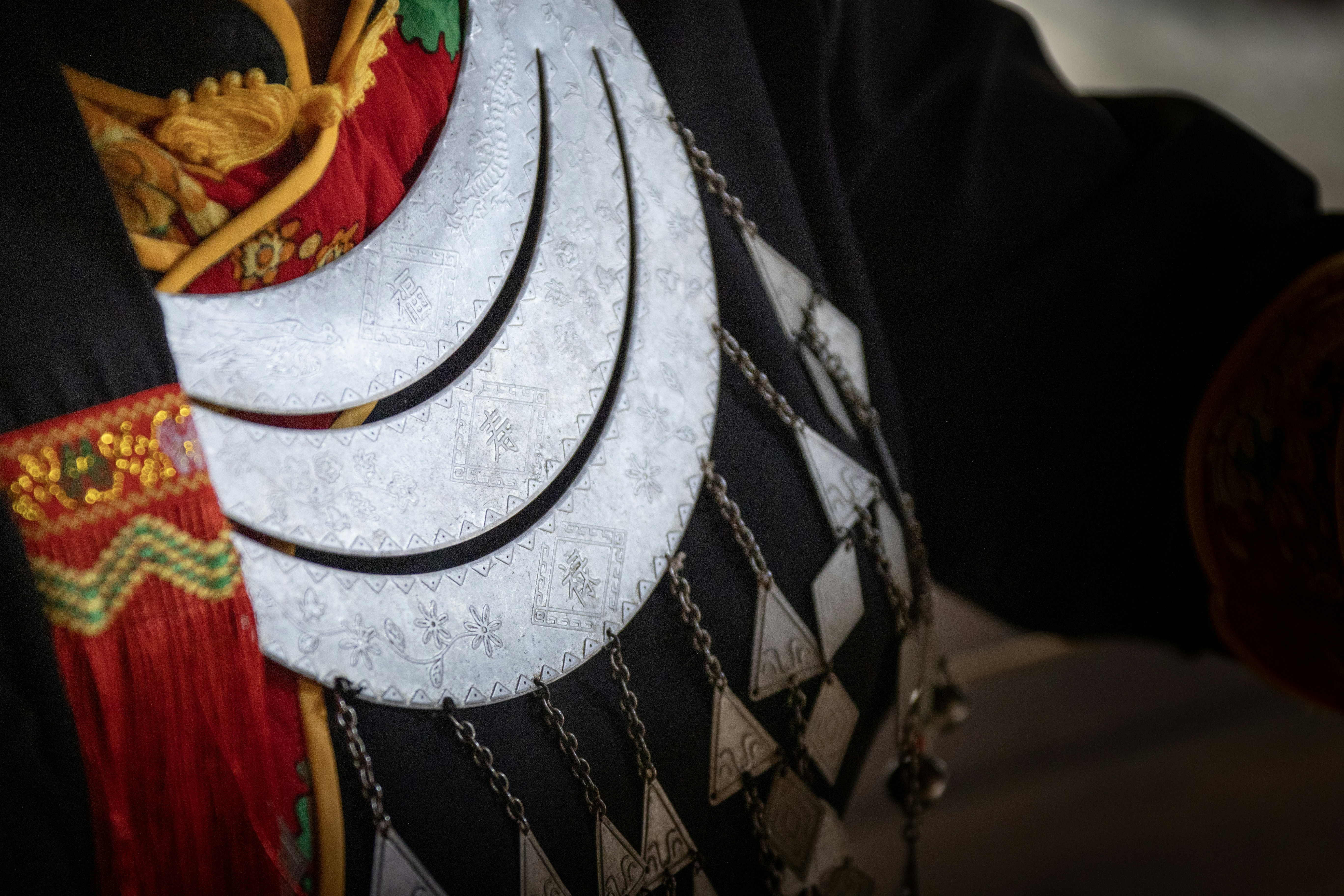 Ornate ceremonial collar in rich textile: a close-up of layered metallic sashes and embroidered patterns