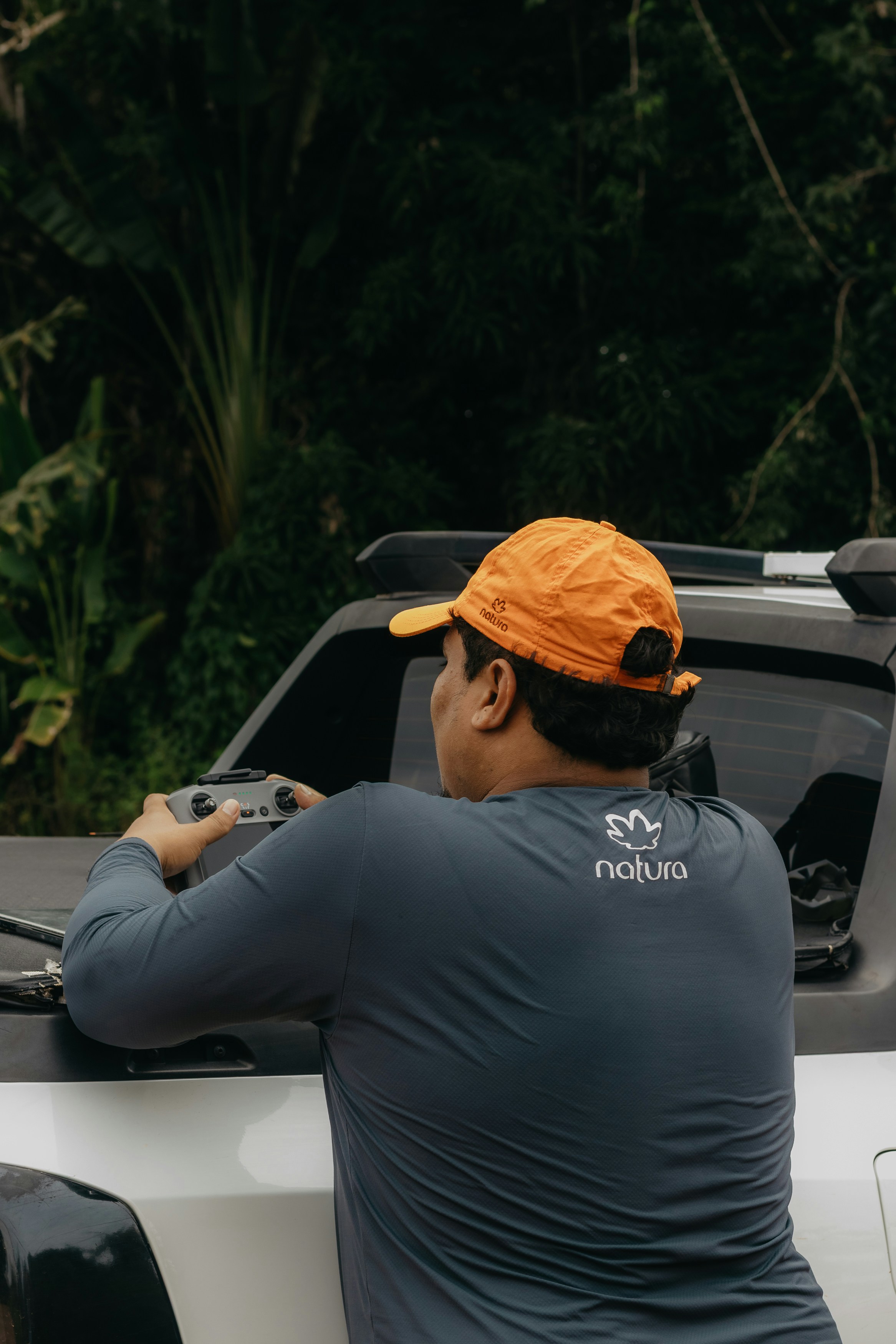 Glimpse of Focus: Man in Orange Cap Steers a Quiet Conversation with the Unseen Trail