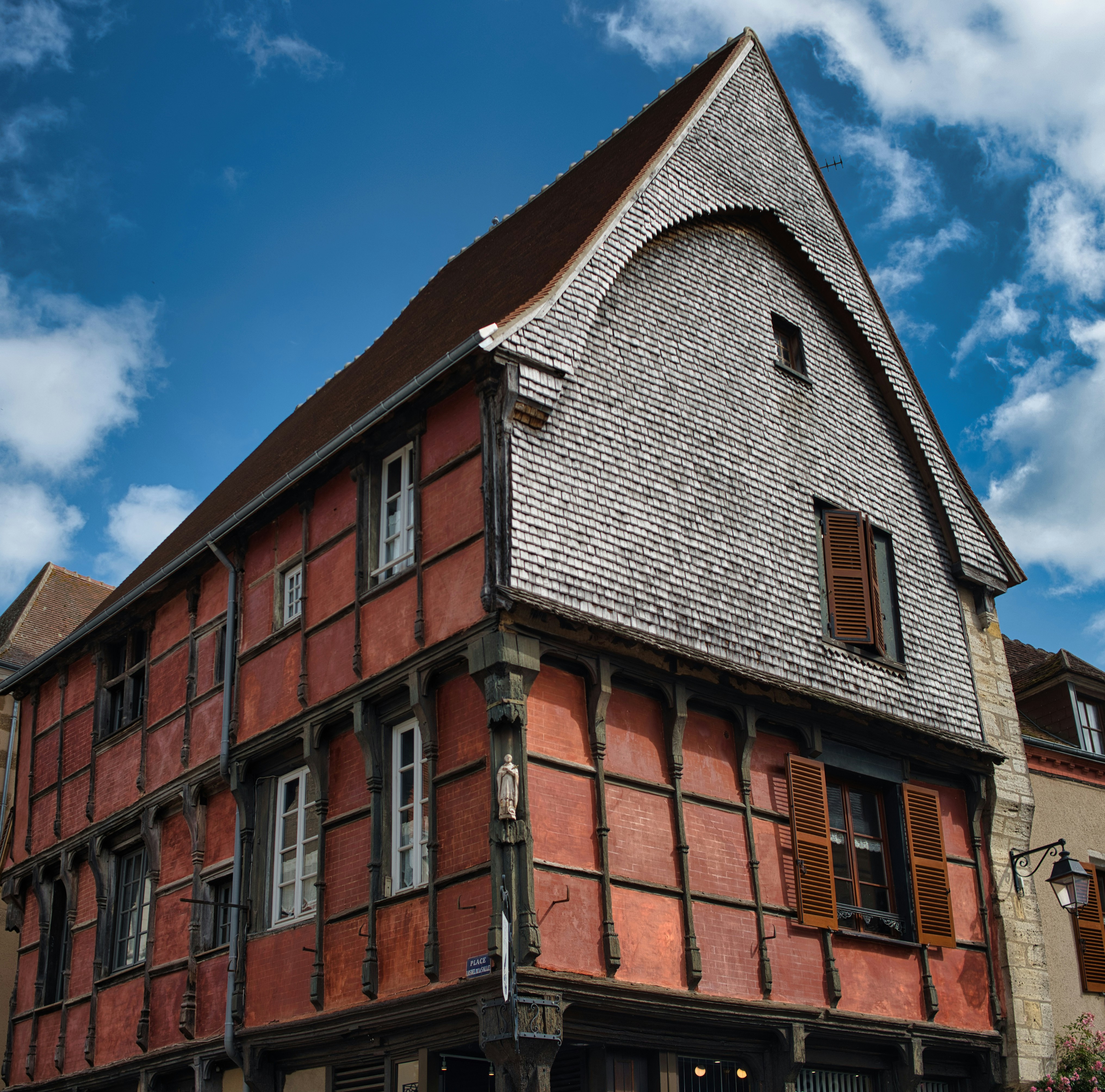 Timber-Framed Gabled Facade Under a Patchwork Sky