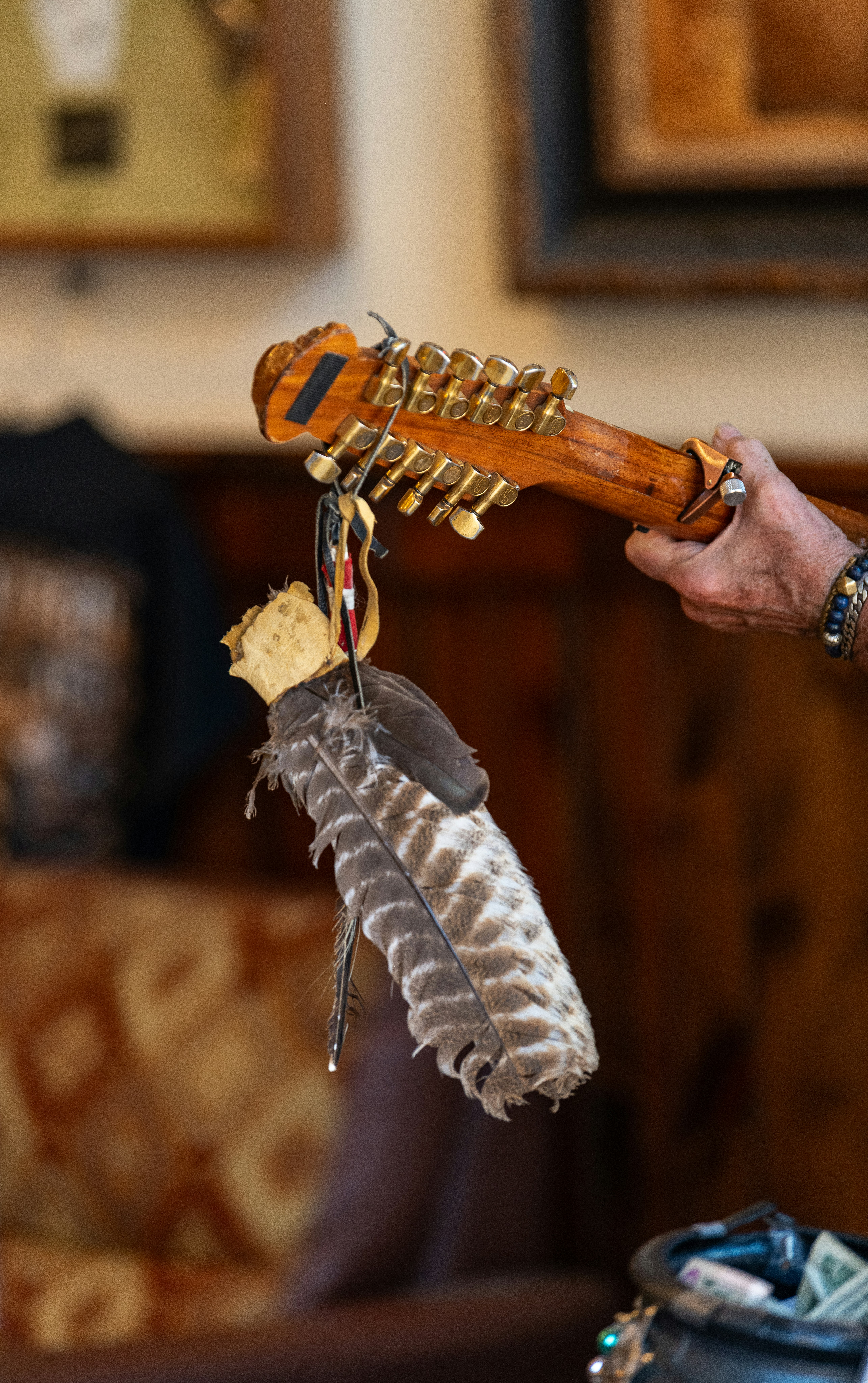 Stringed Harvest: A Guitar Headstock and Feather in Focus