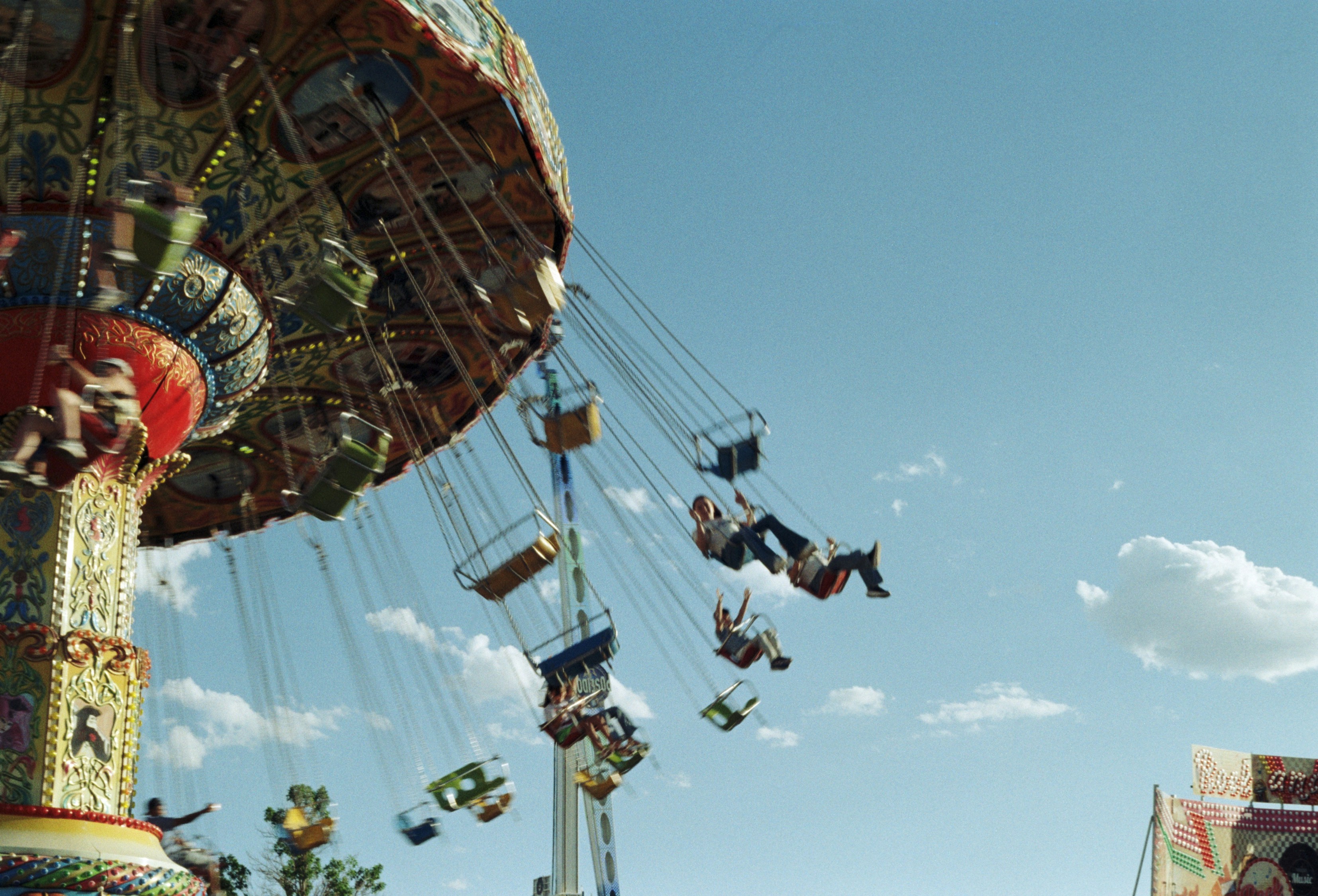 Swinging Lights and Sky: A Carnival Ride in Full Spin