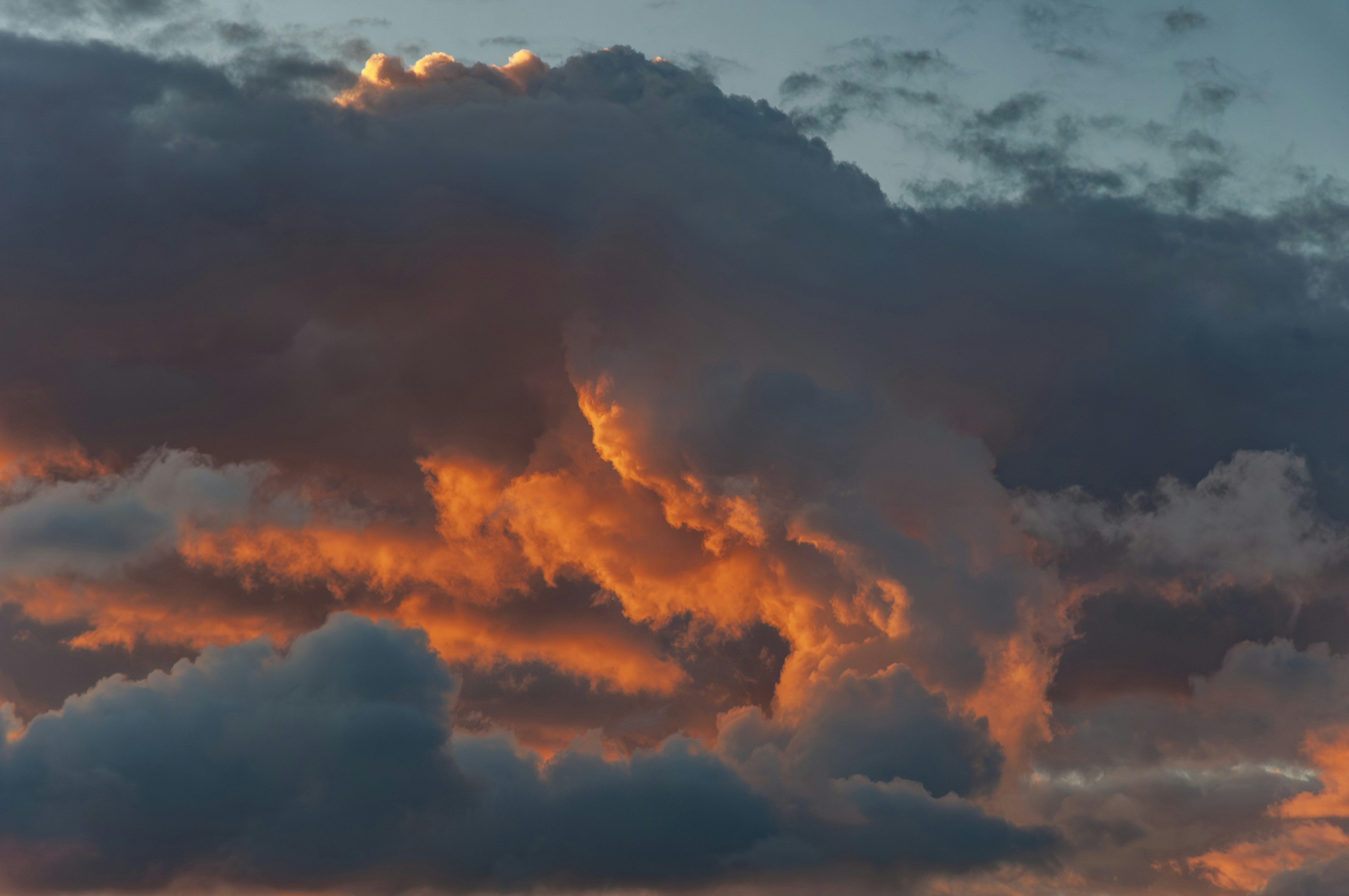Crimson Edge: Sunset Flames Amid Voluminous Clouds