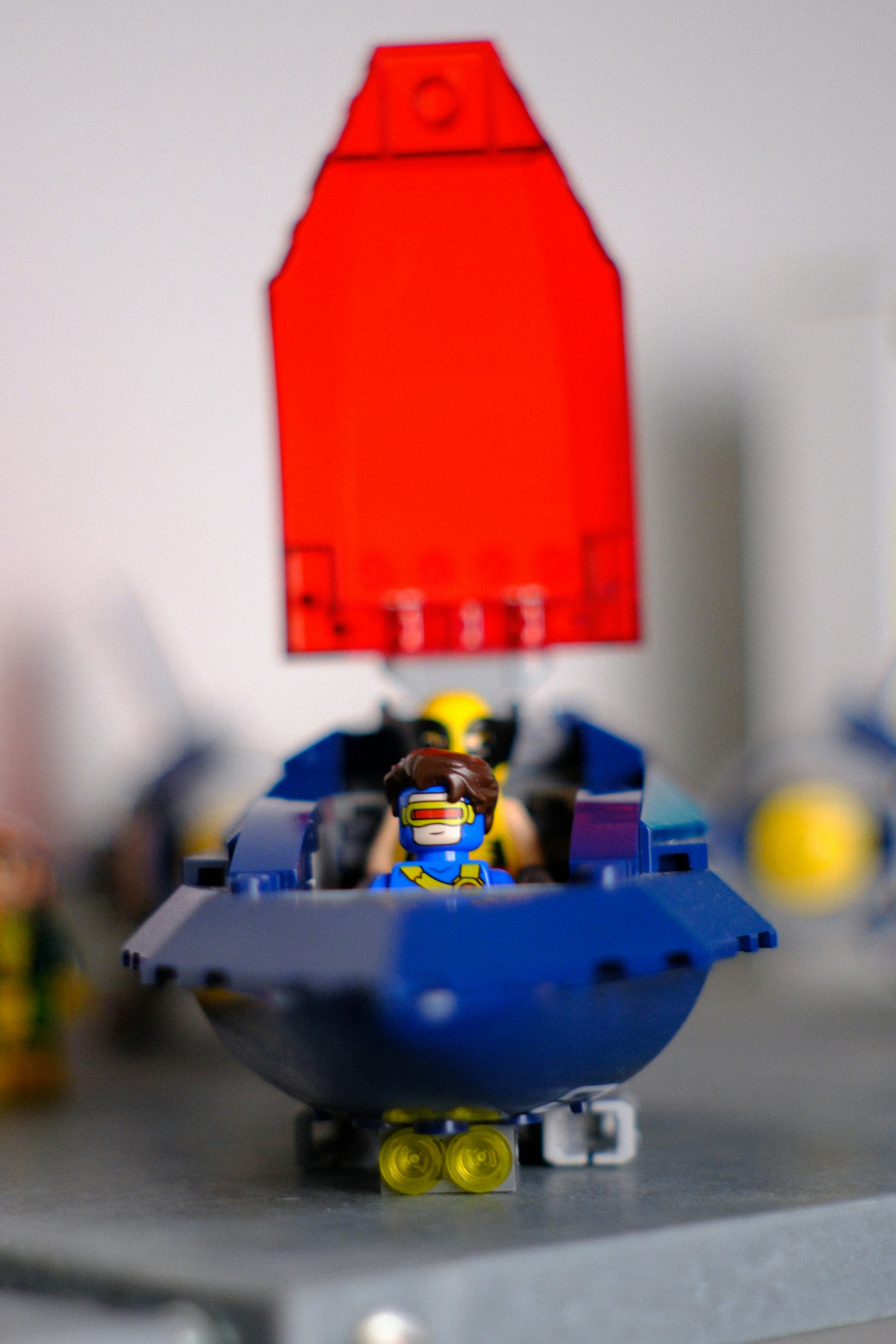 Lego cyclops minifigure in blue spaceship, red canopy open.