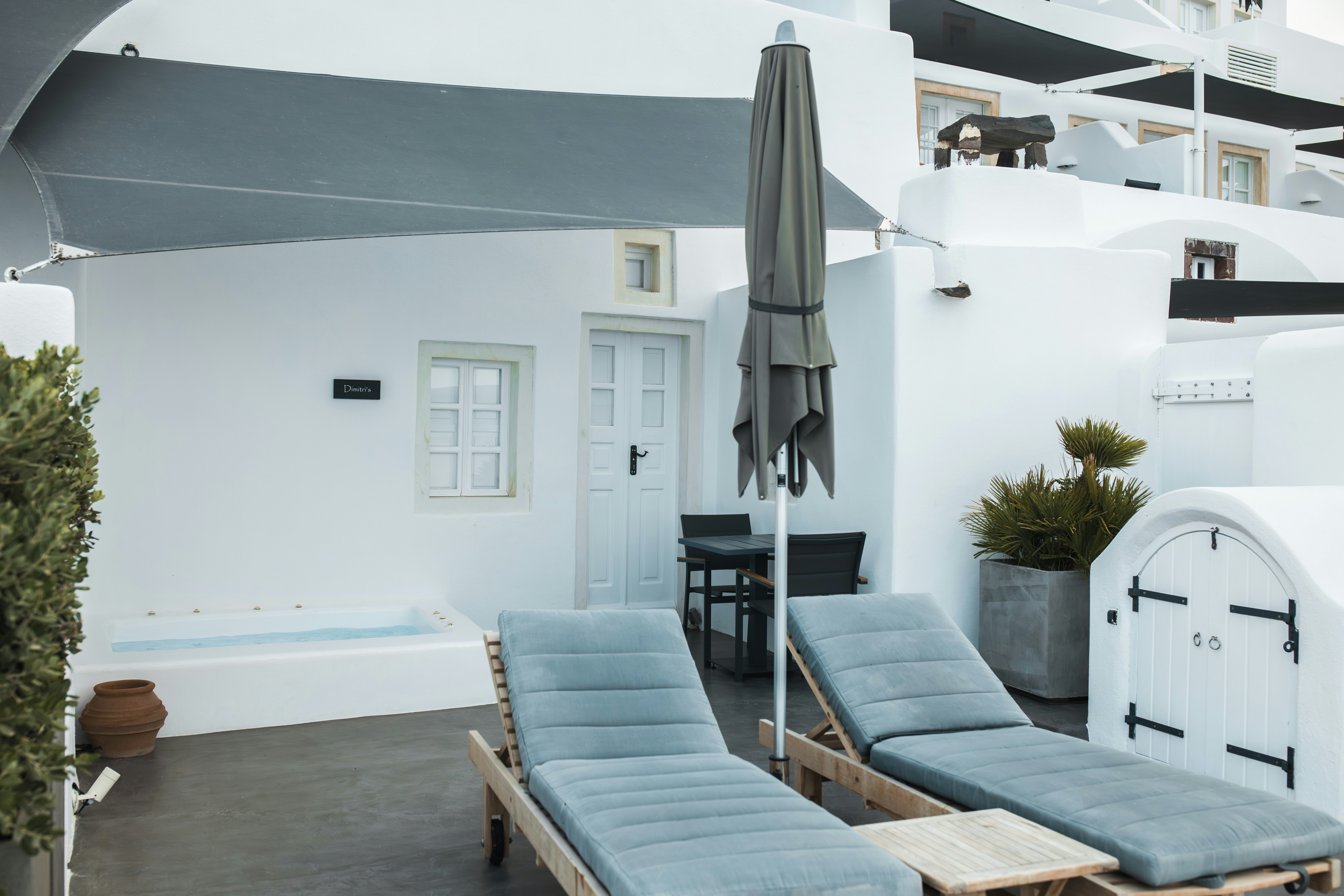 Sunlit White-Washed Terrace with Cushioned Loungers and Ocean-View Aesthetic