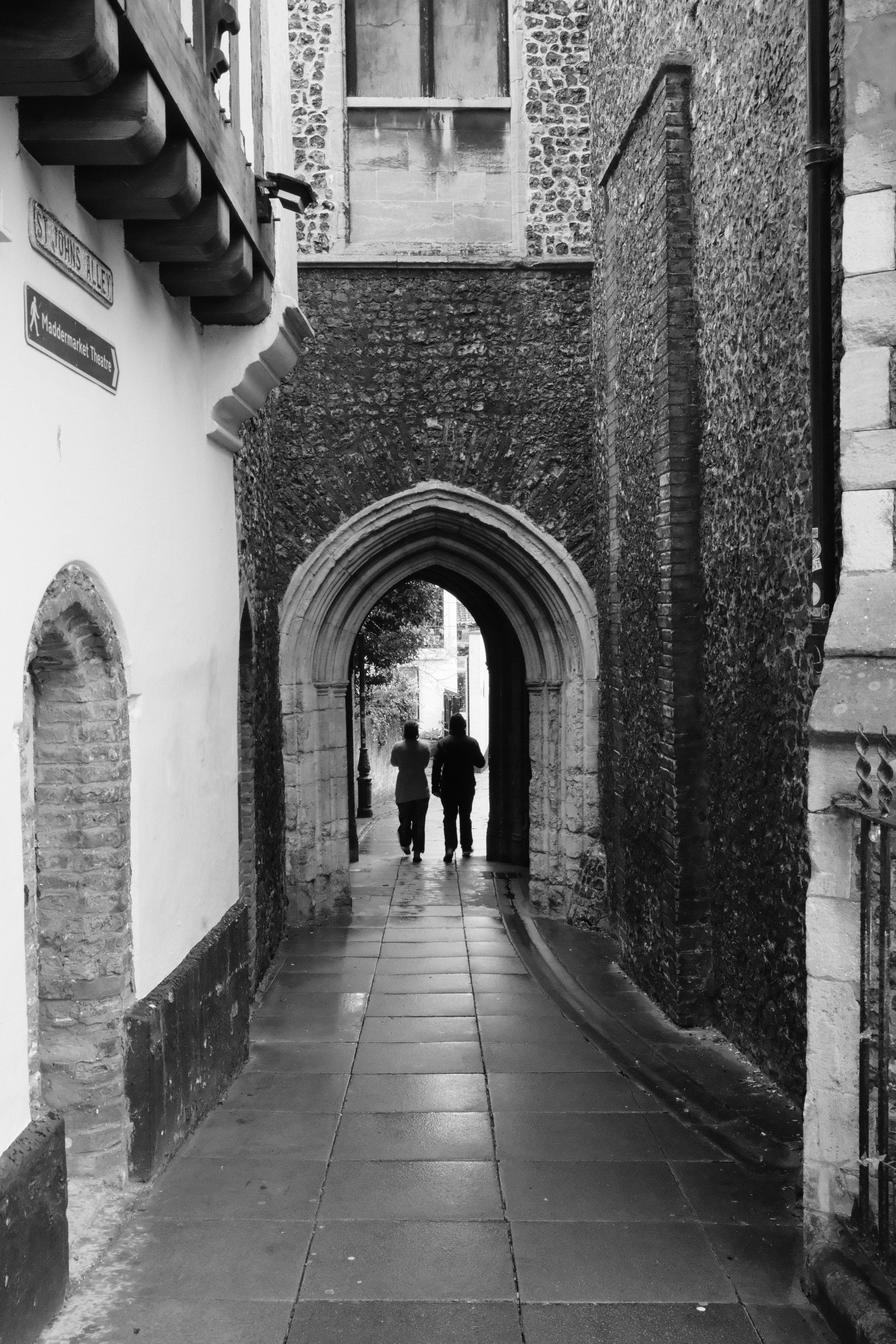 Archway Corridor: Silhouettes in a Narrow Alley
