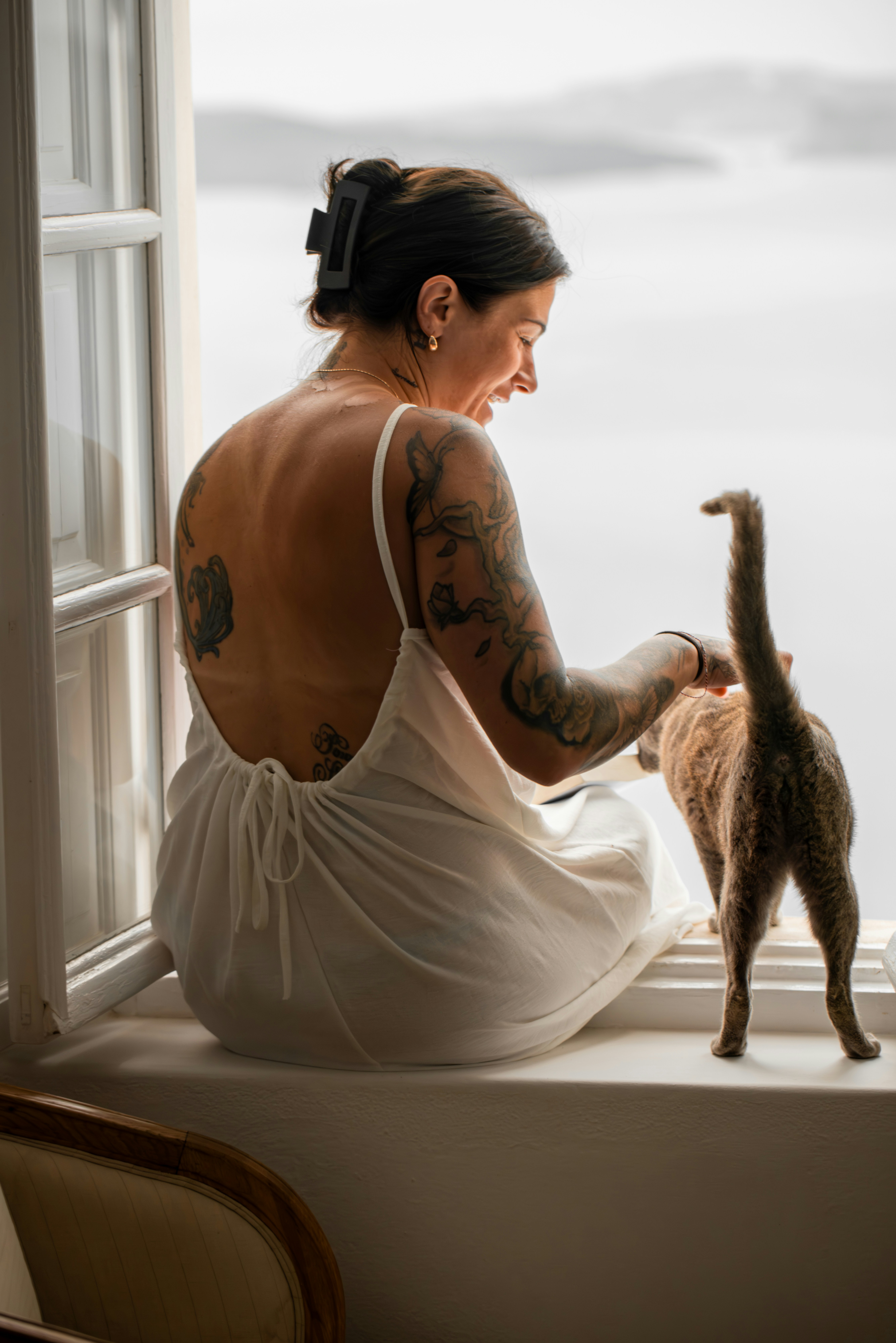 Sunlit Window, Tattooed Portrait, and a Curious Cat