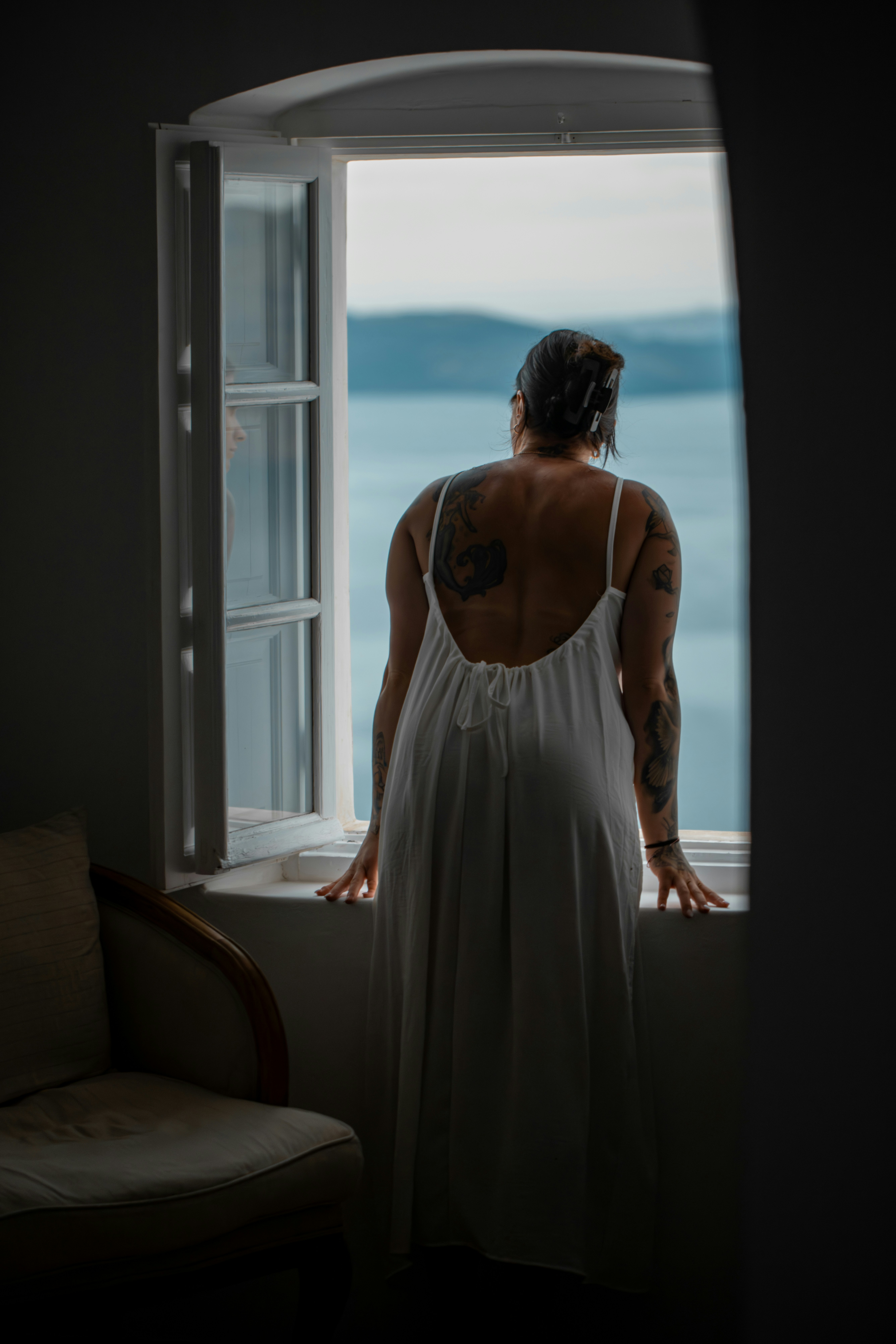 Window to Quiet Strength: A Back Portrait Framed by Light