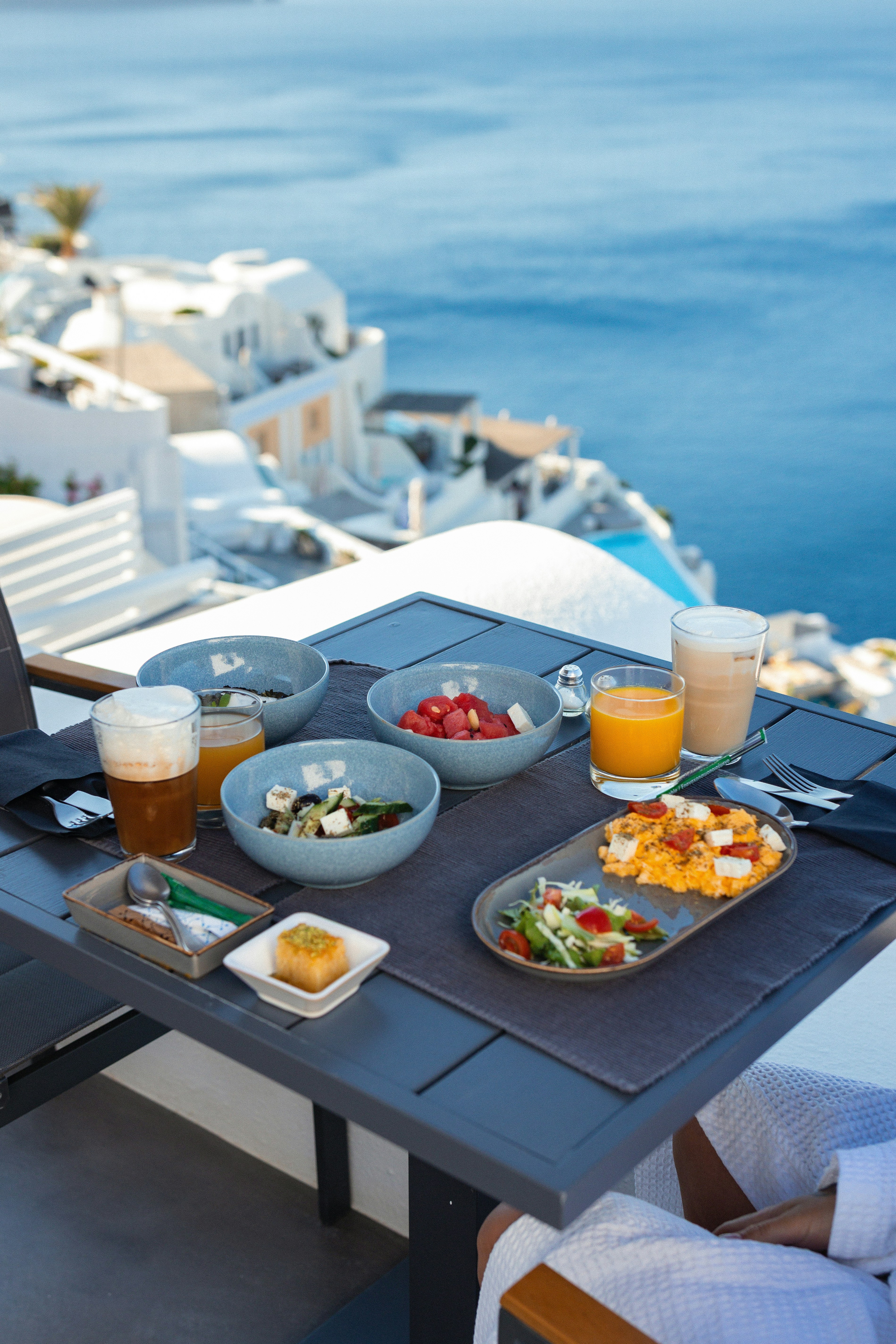 A sunlit coastal breakfast on a terrace overlooking blue Aegean waters