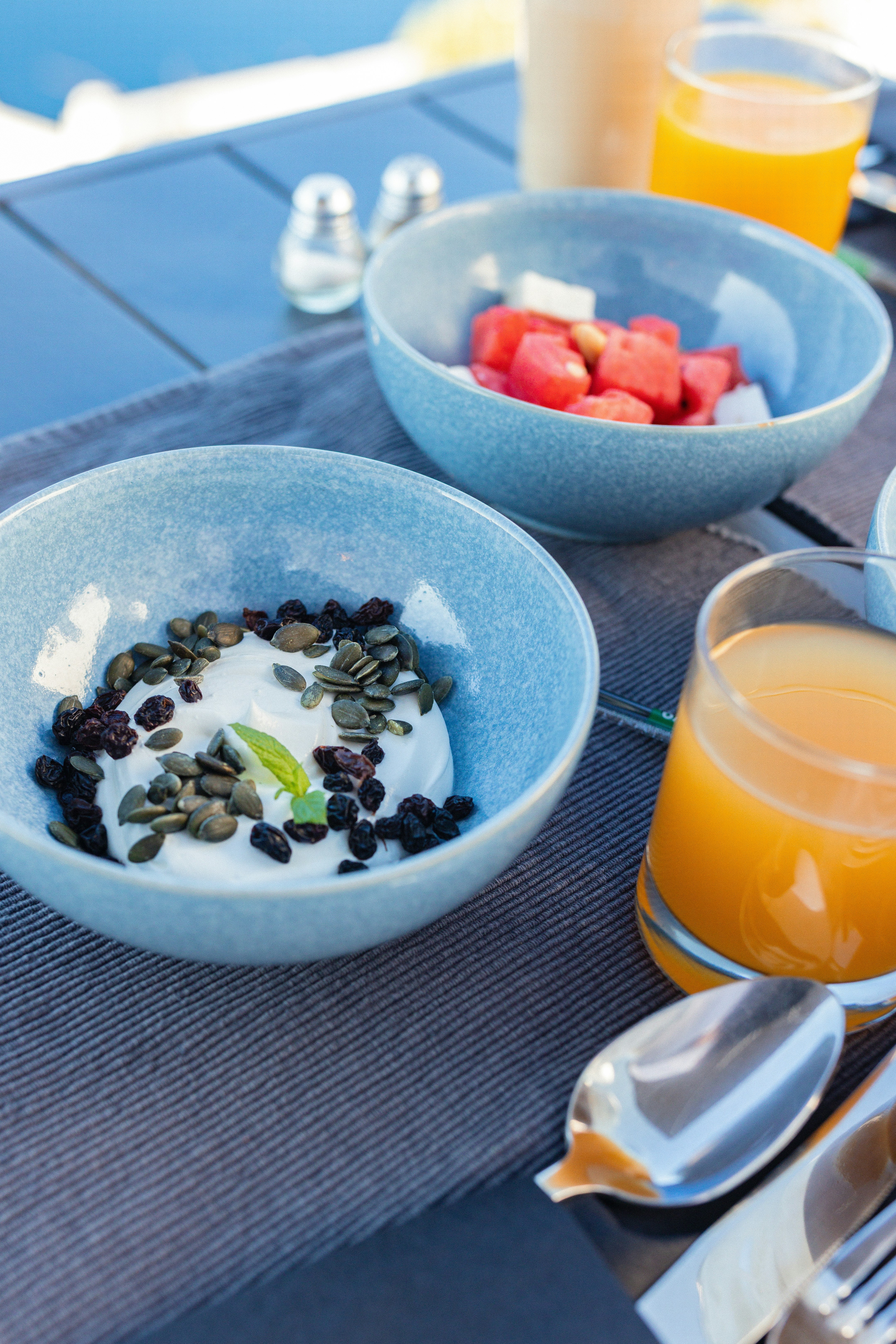 Blue Bowls, Bright Morning: Yogurt, Fruit, and Orange Juice on a Striped Table