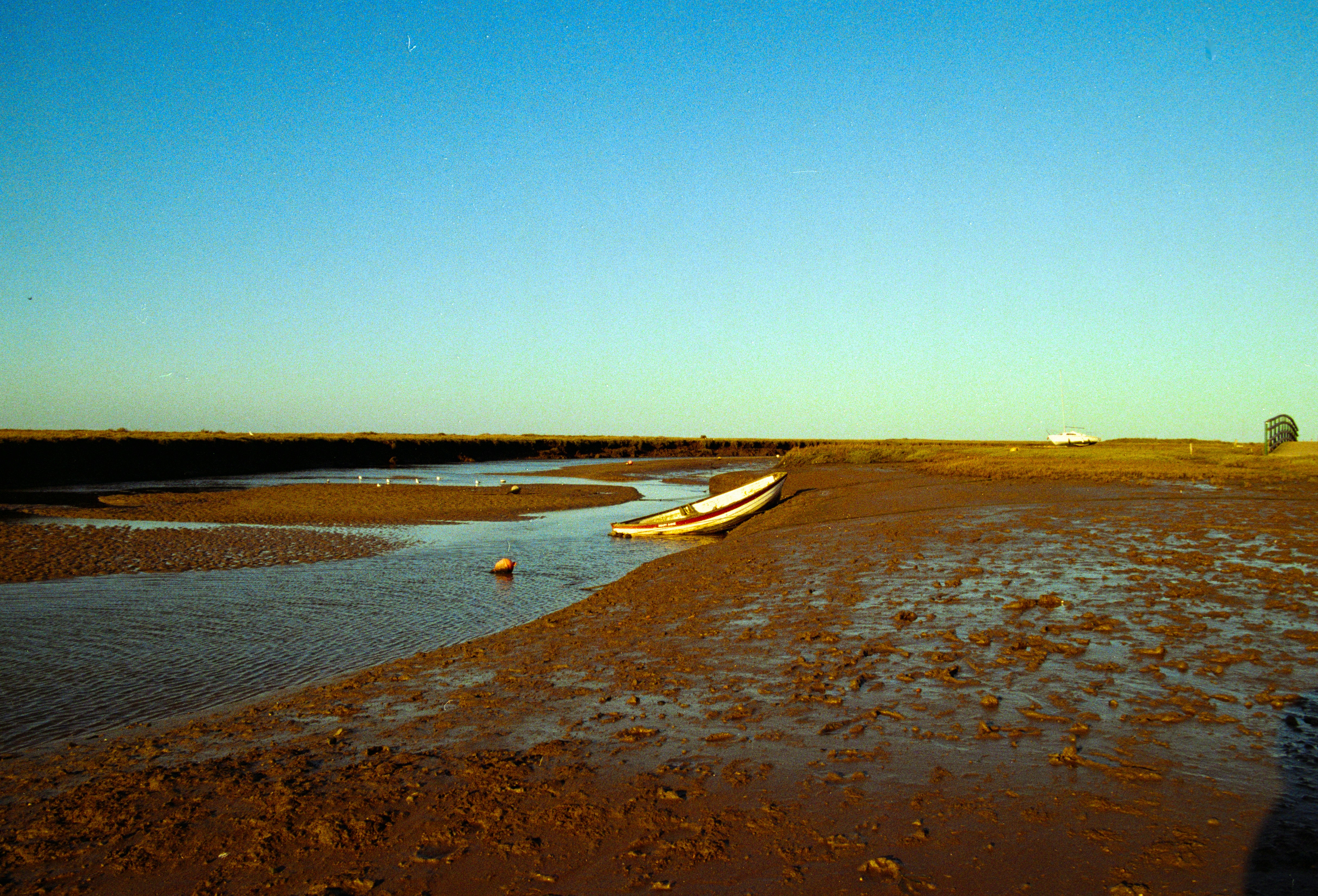 Boat Beached on a Briny Dune under a Wide Sky