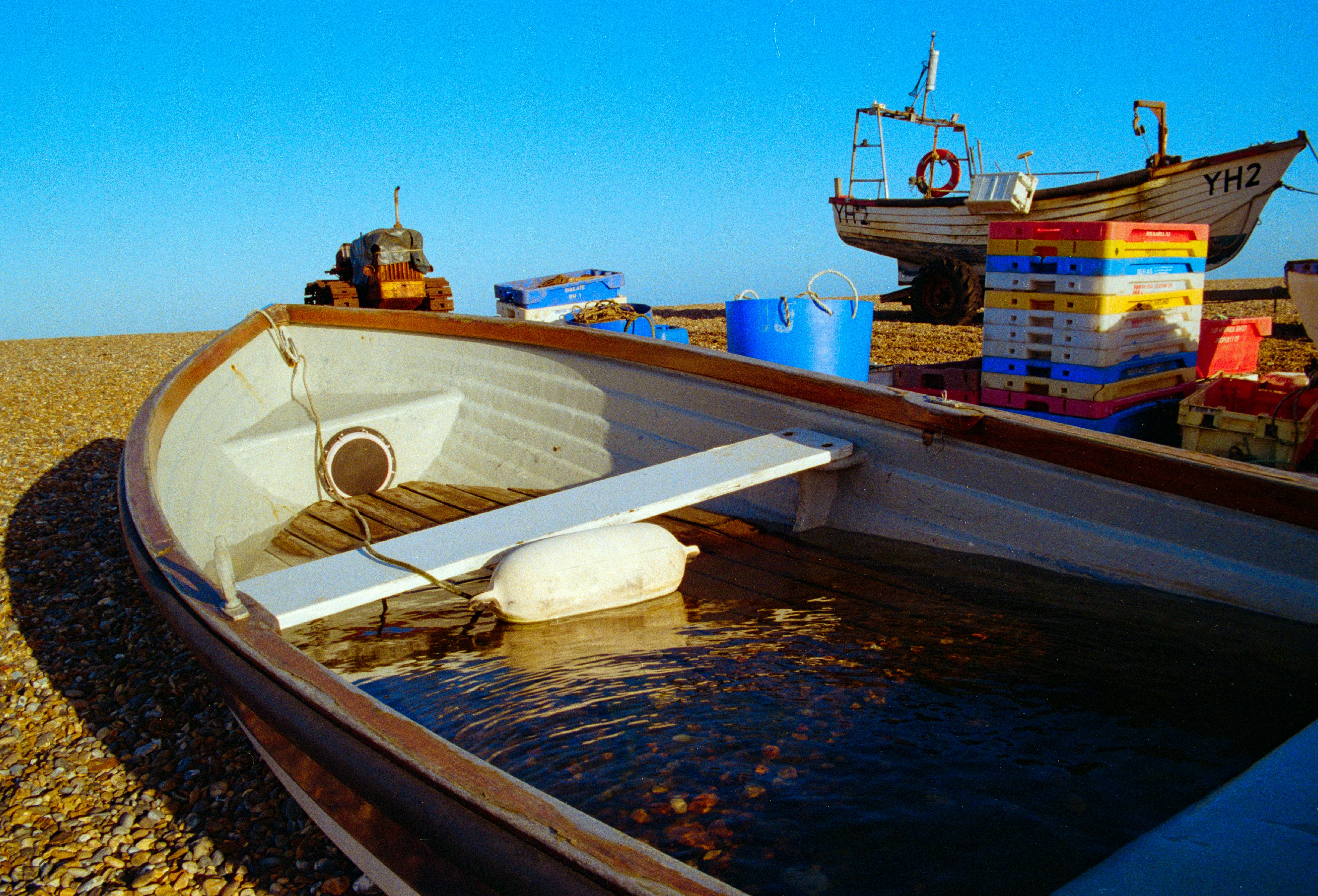 Sunlit Harbor Cargo: A Quiet Beach Scene with Boats and Docks