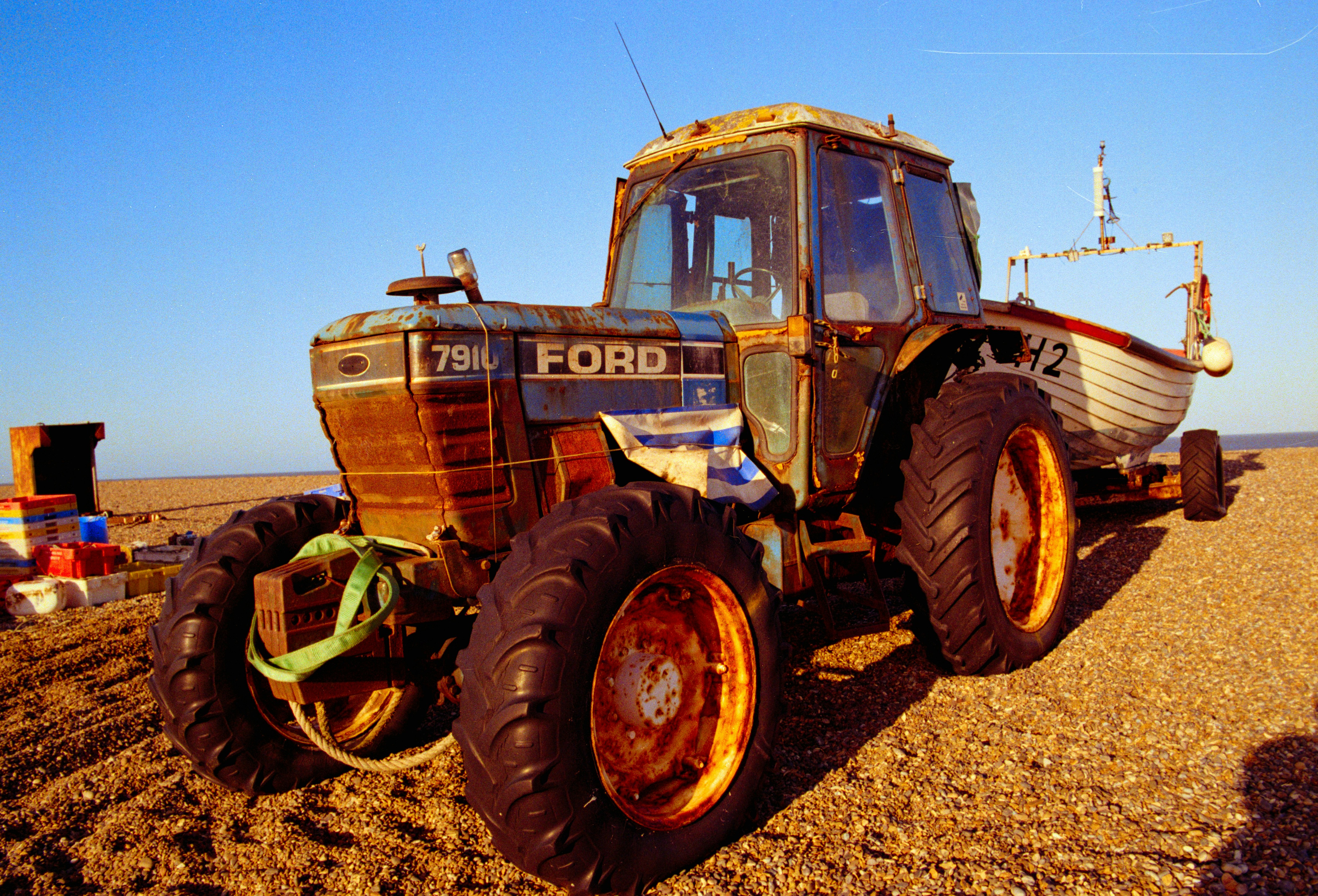 Rust-Red Tractor on a Sunlit Beach, Waiting for Fields