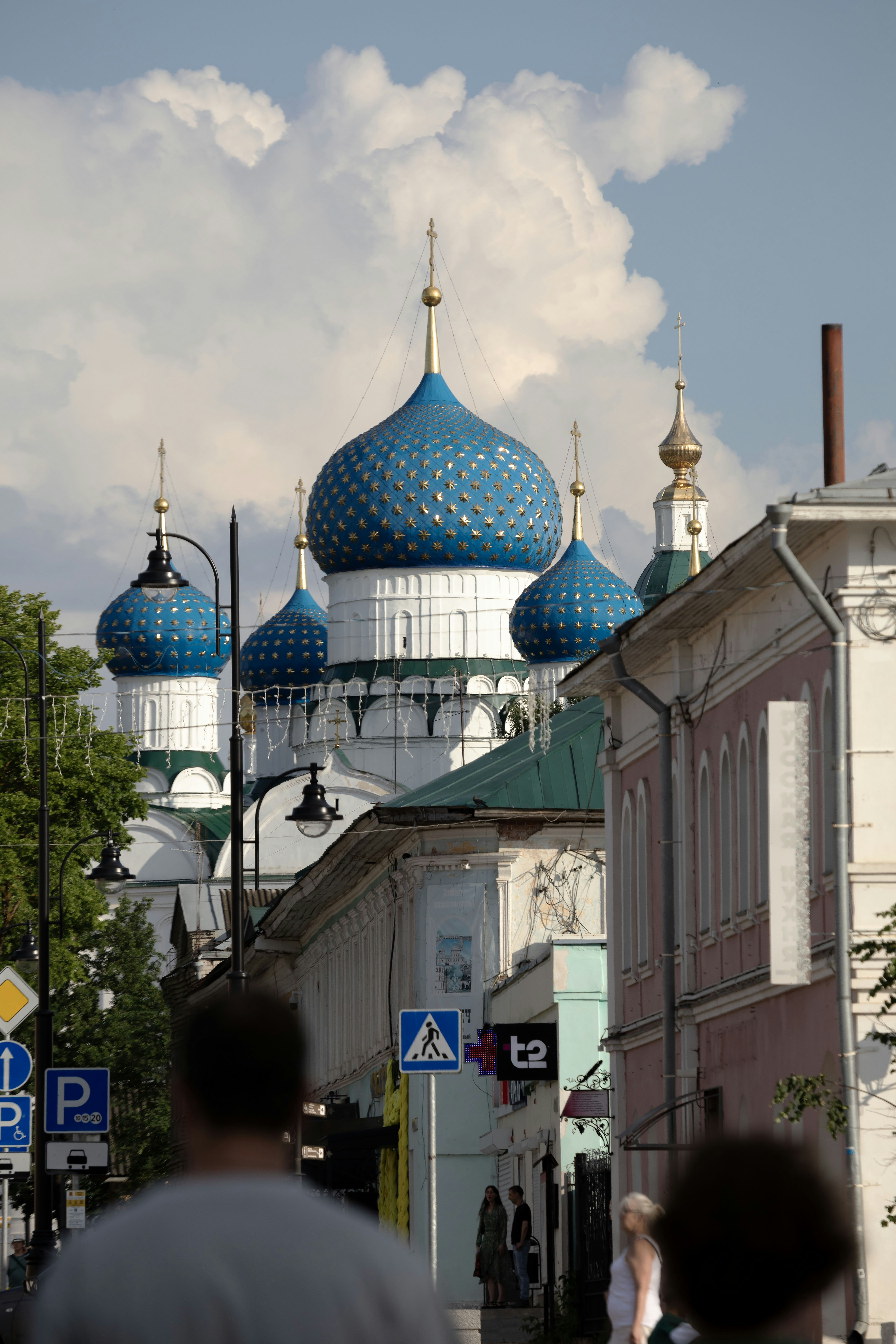 Blue domes under a sunlit sky dominate a quiet street