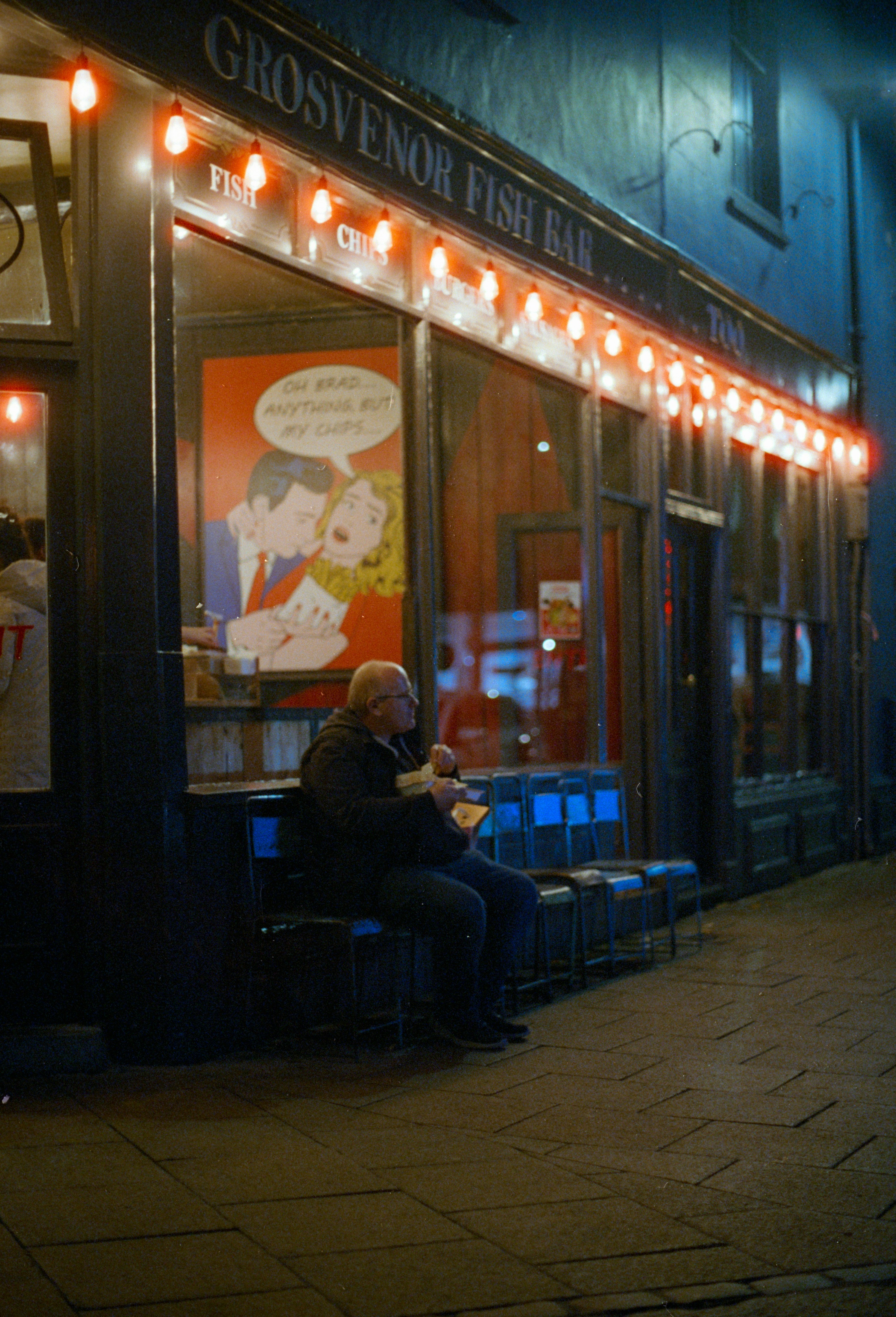 Lonely Table at Grosvenor: A Night Scene with Warm Neon Glow