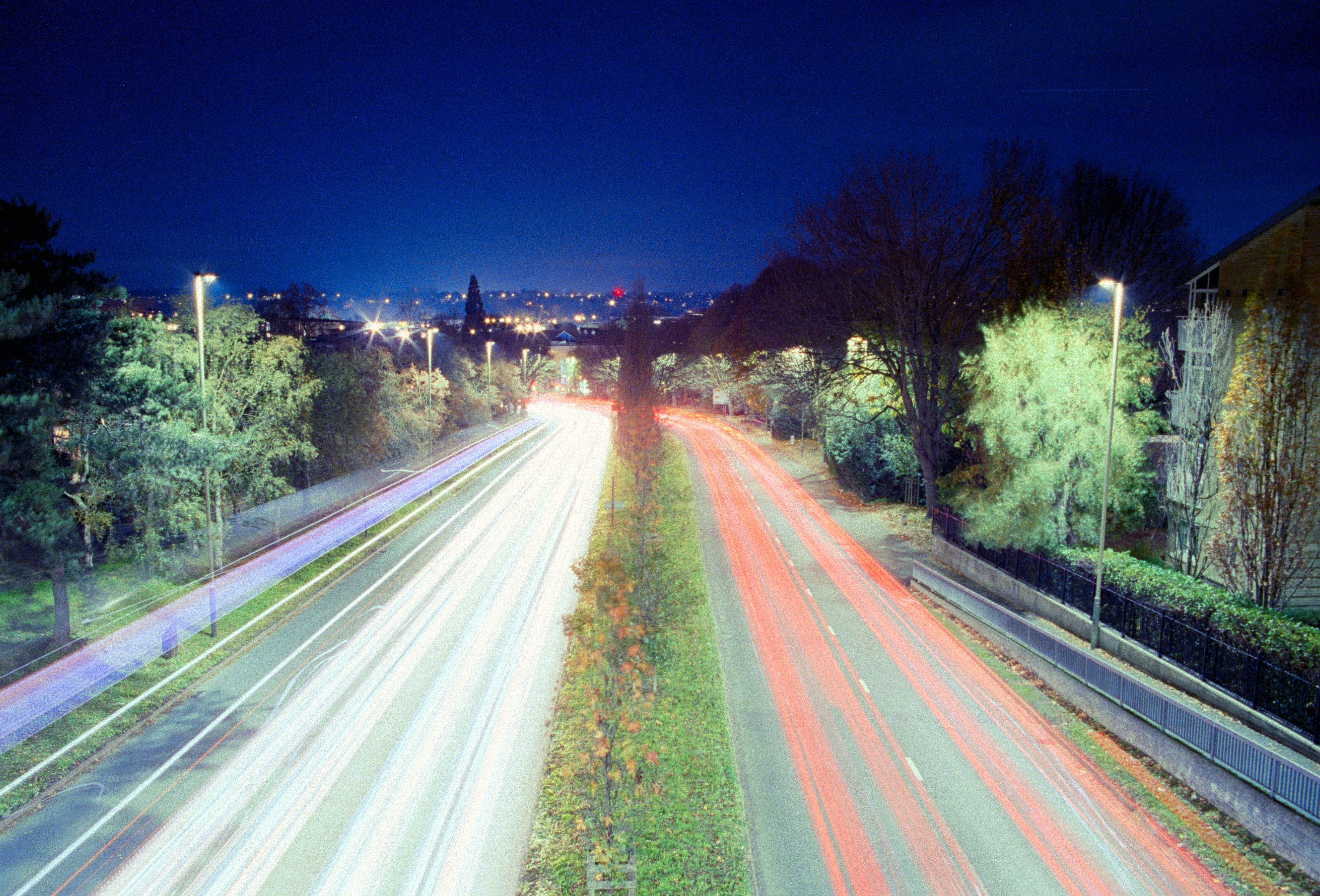 Night Street Echoes: Light Trails Converge Toward the City