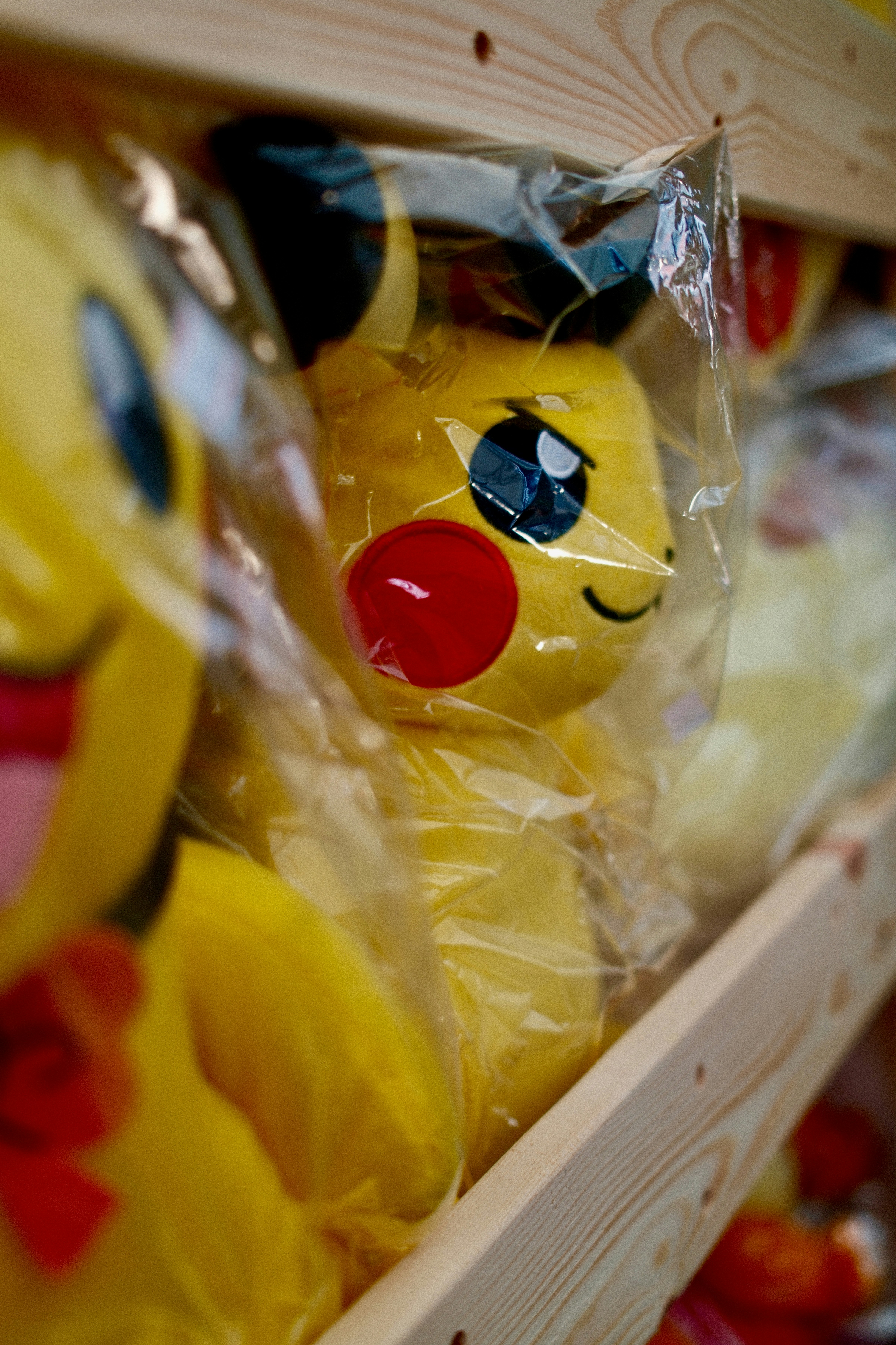Yellow Plush Glow: Pikachu Peeks Through Plastic in Shelved Display