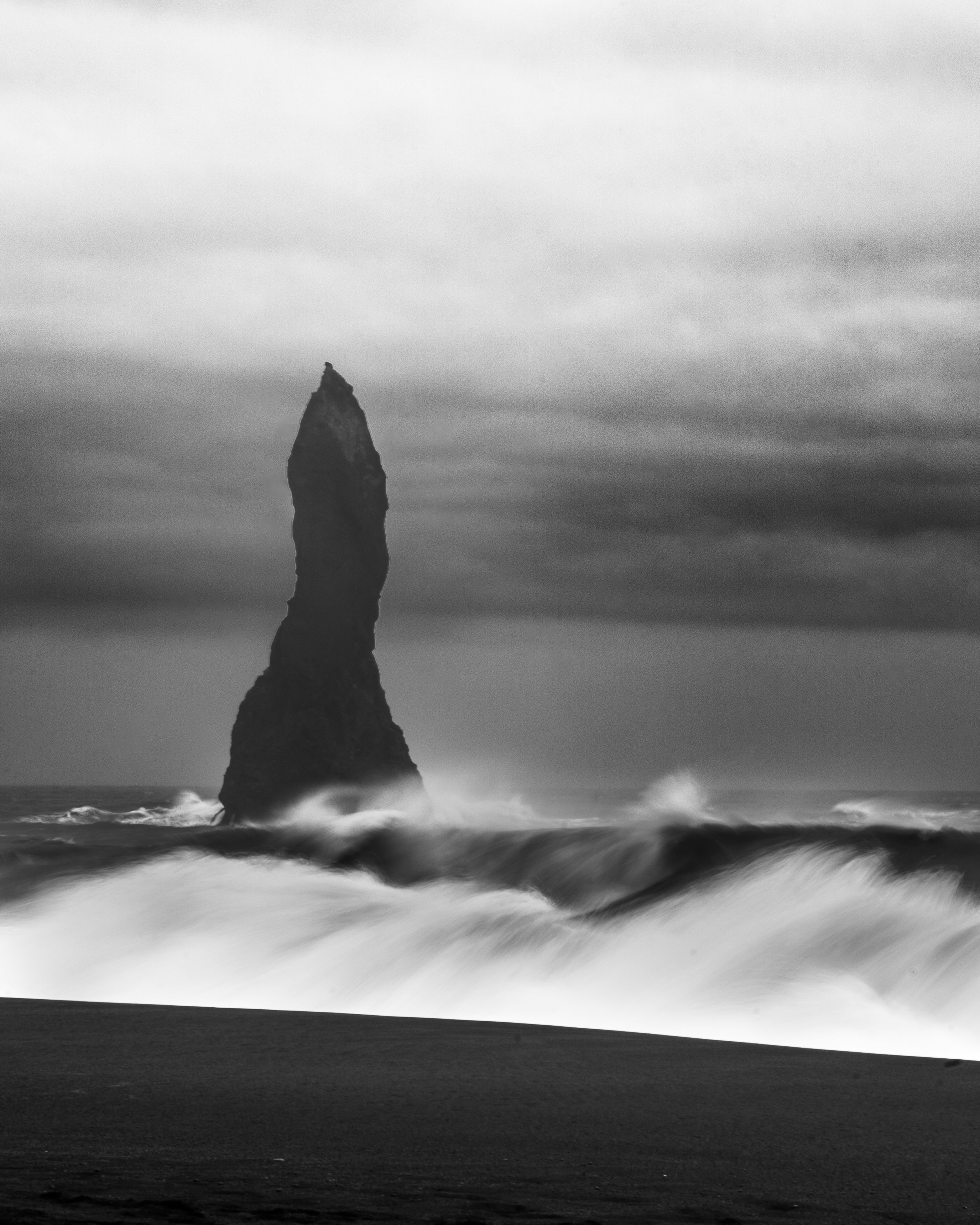 Monolith at Sea: A Lone Spine Rising from the Tide