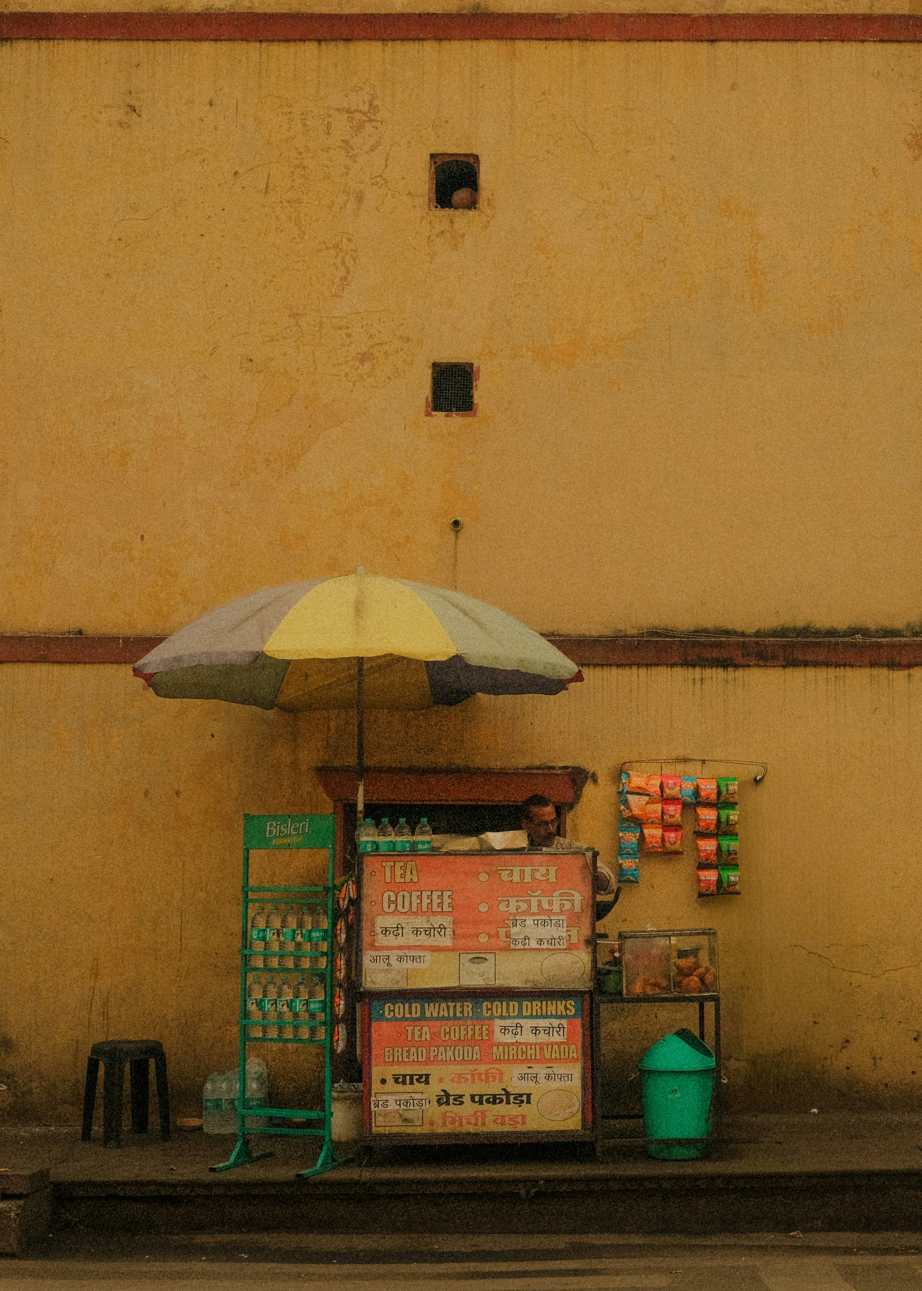Yellow-Walled Street Vendor Under a Multicolored Parasol