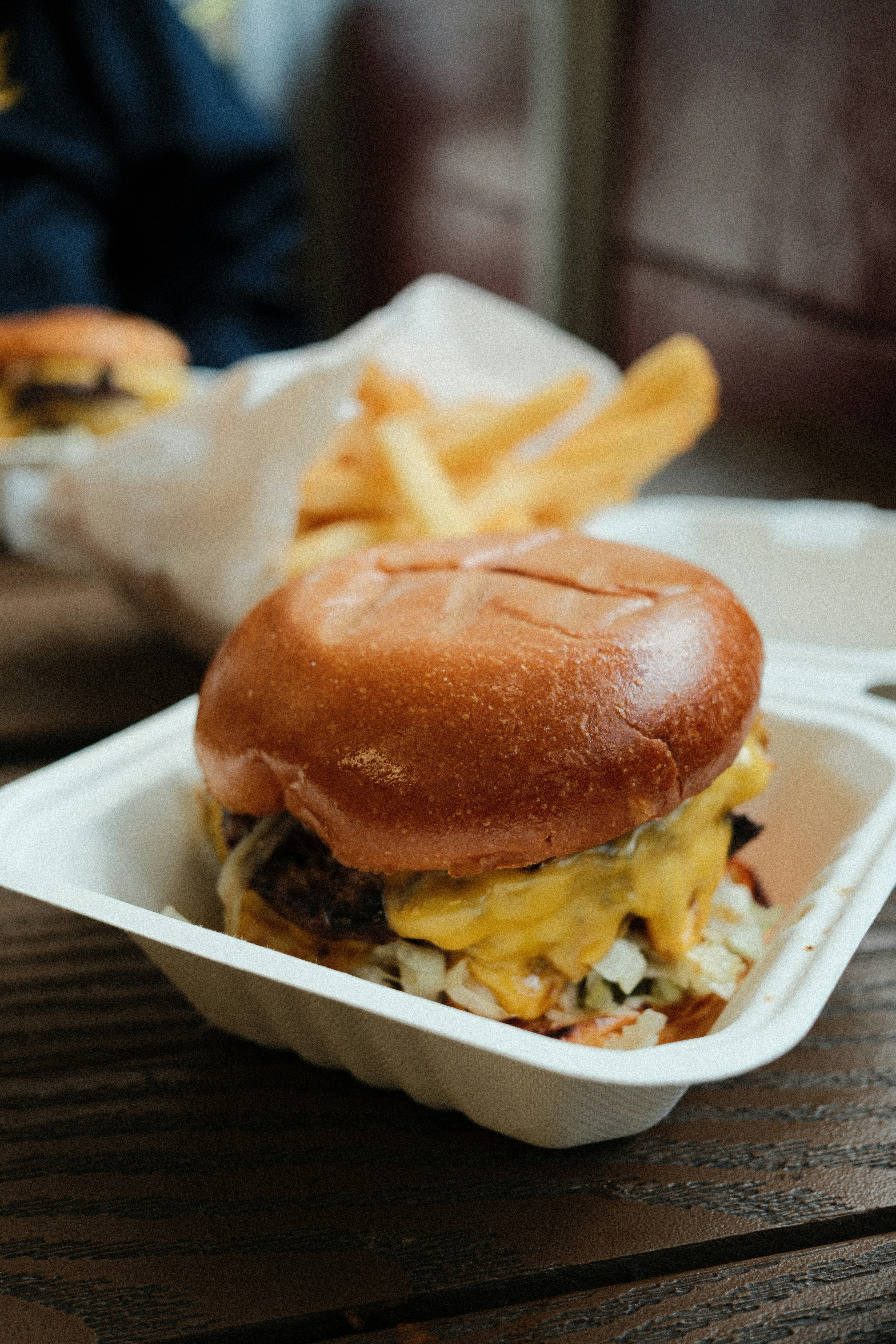 Cheeseburger with melted cheese and onions, served with fries.