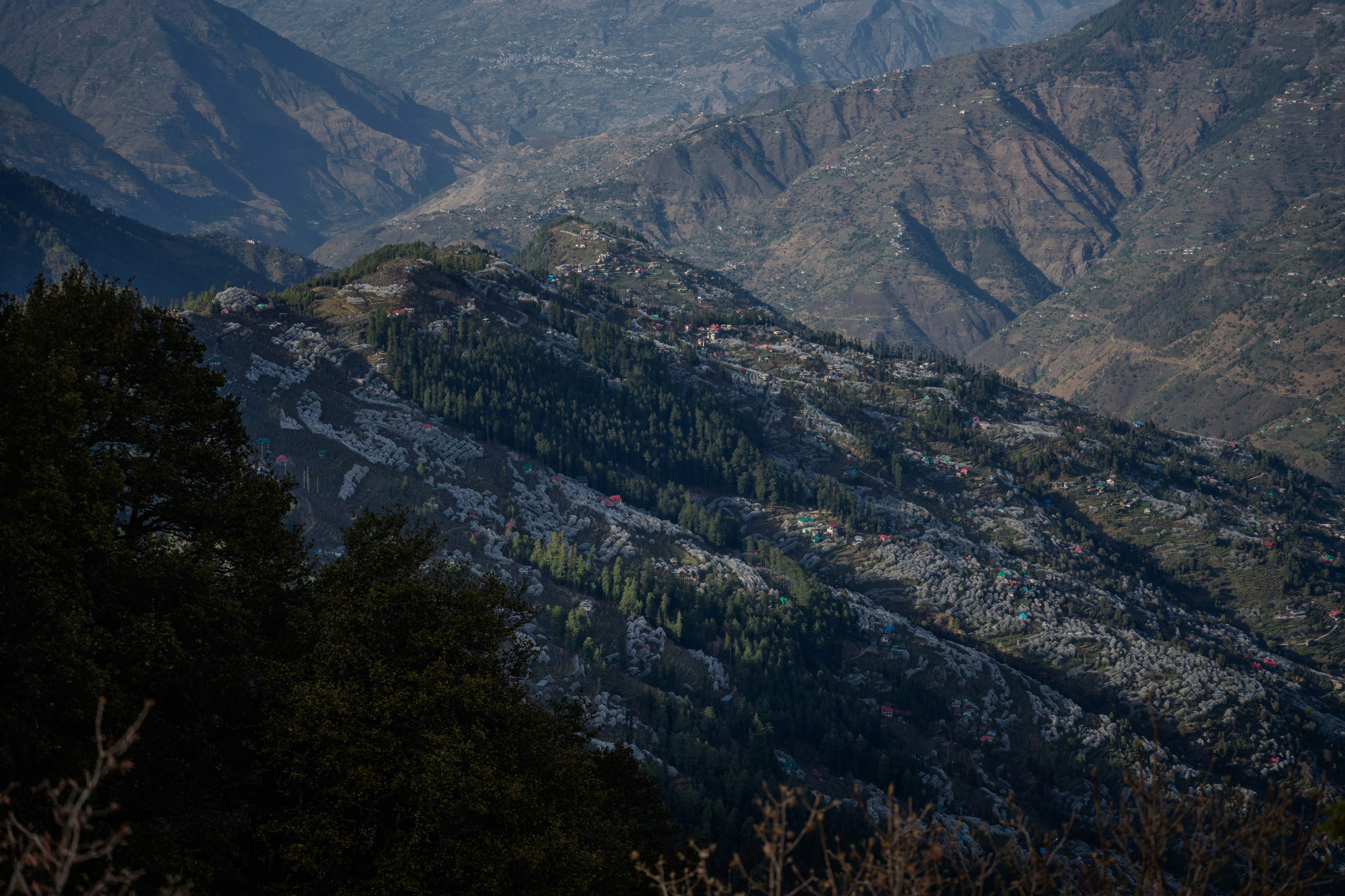 Slope shadows over a village stitched into the alpine valley