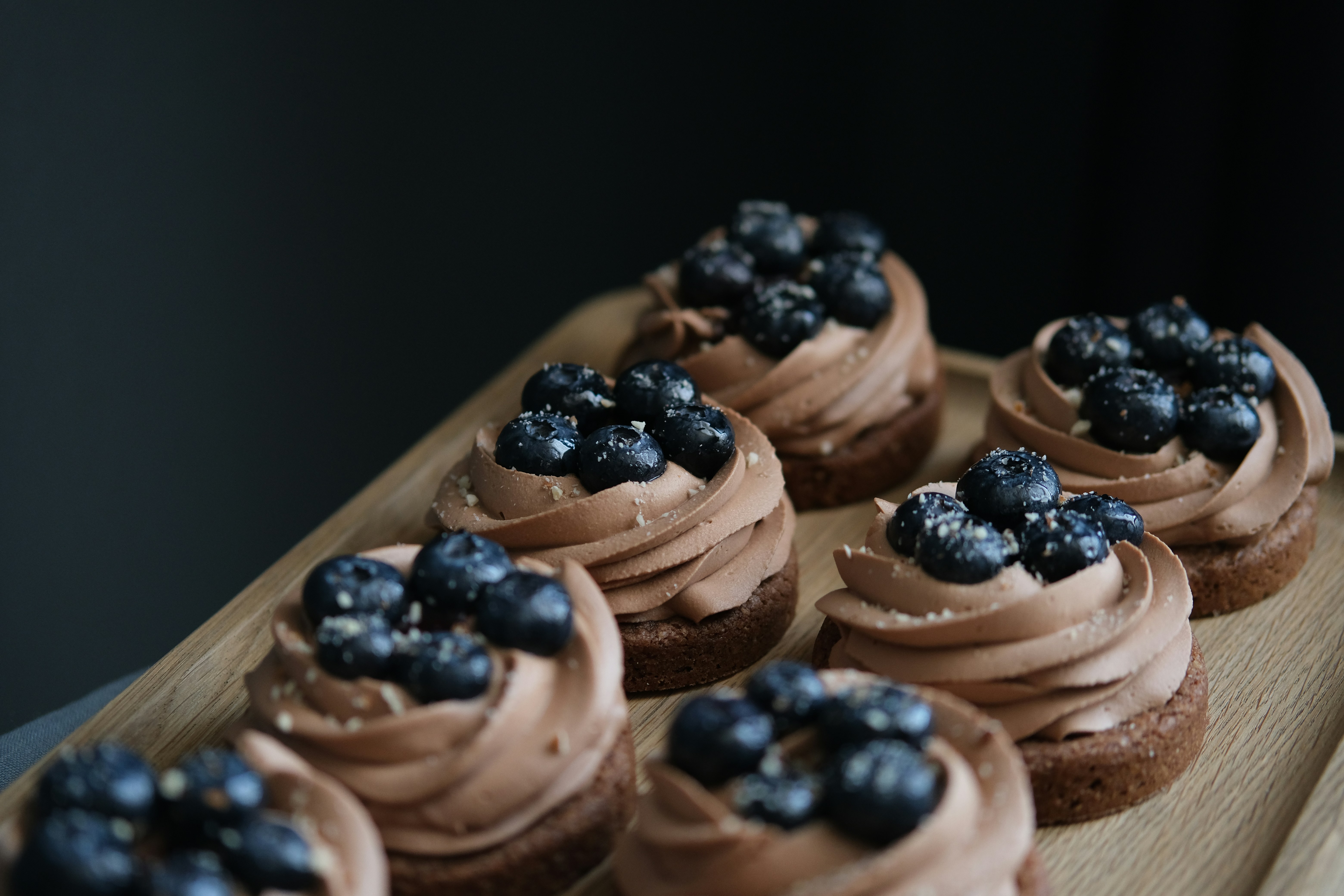 Chocolate Cream Topped Confections on a Wooden Board