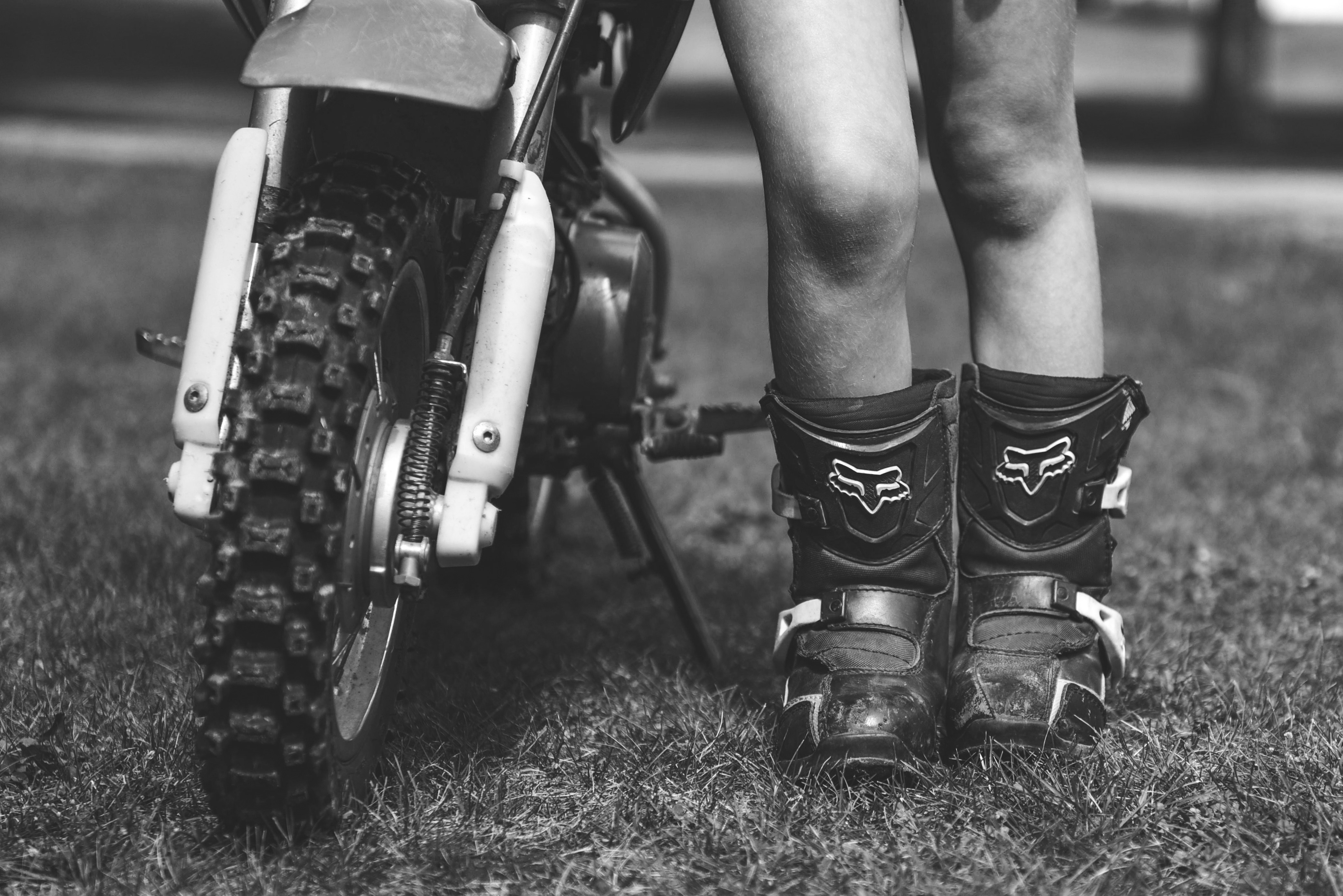 Tiny Boots, Big Ride: Boyish Focus beside the Motorcycle