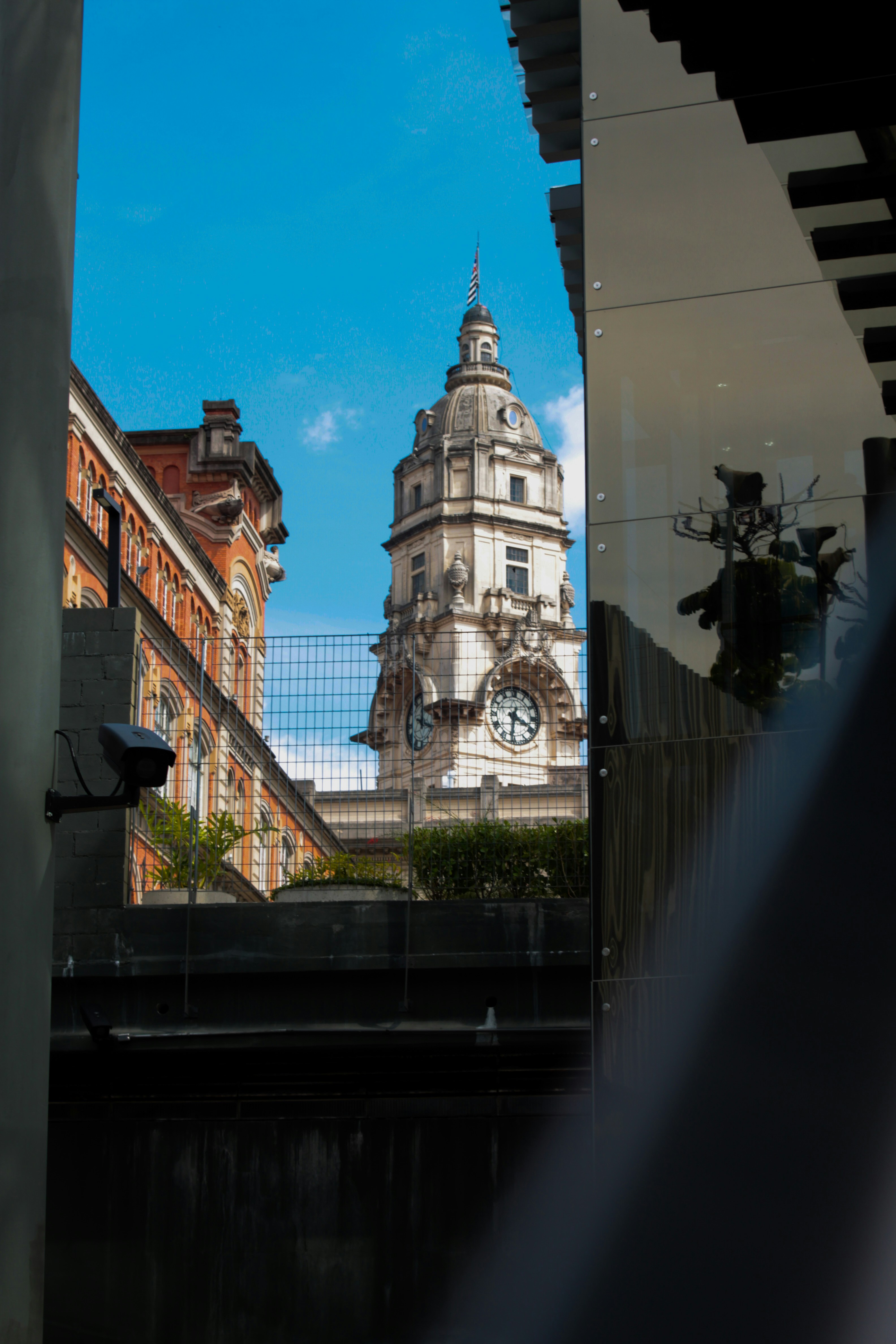 Clock Tower in a Glass-Waced City Cut Between Modern Corners