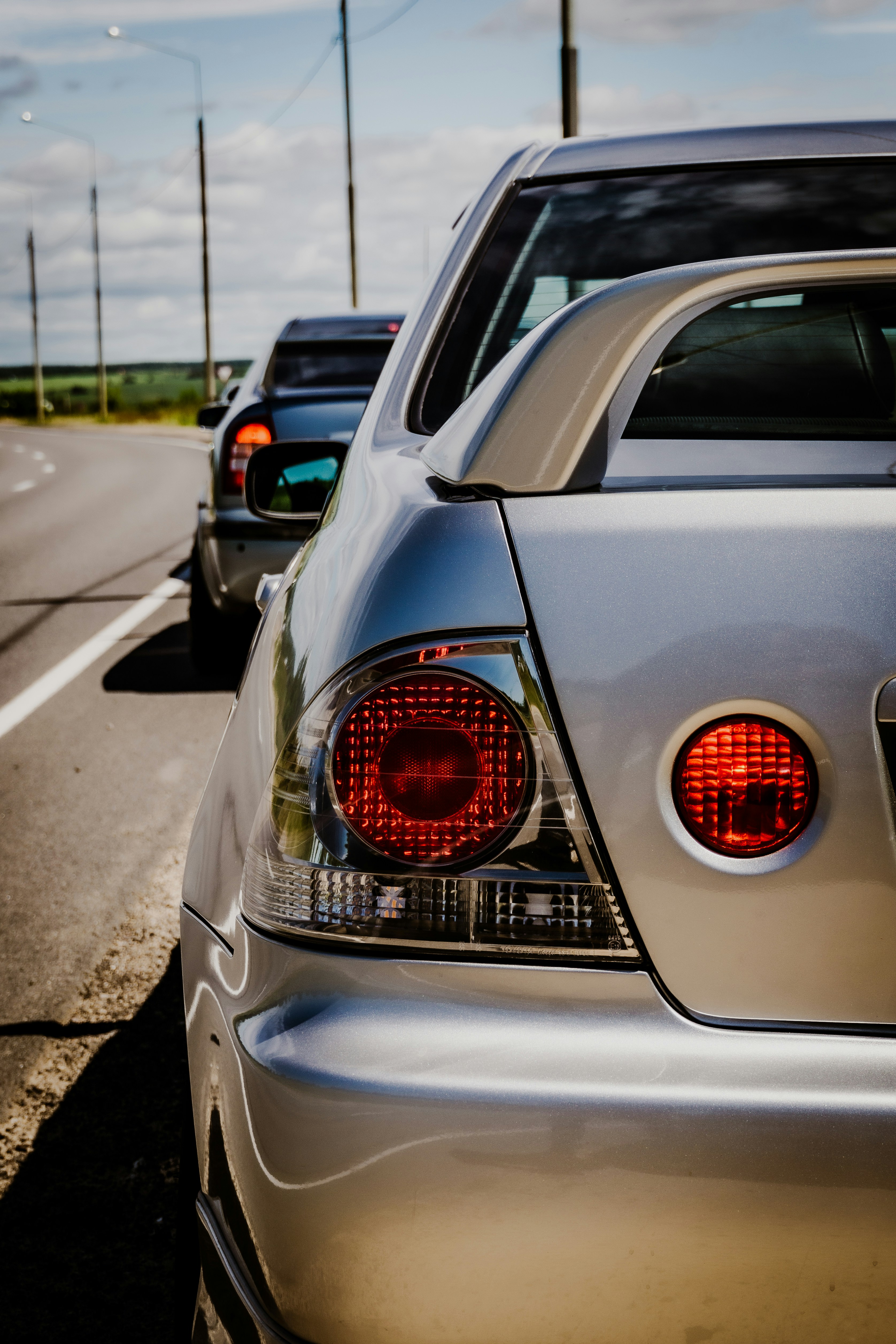 Rear View Mirror: Stacked Taillights on a Silver Sports Sedan
