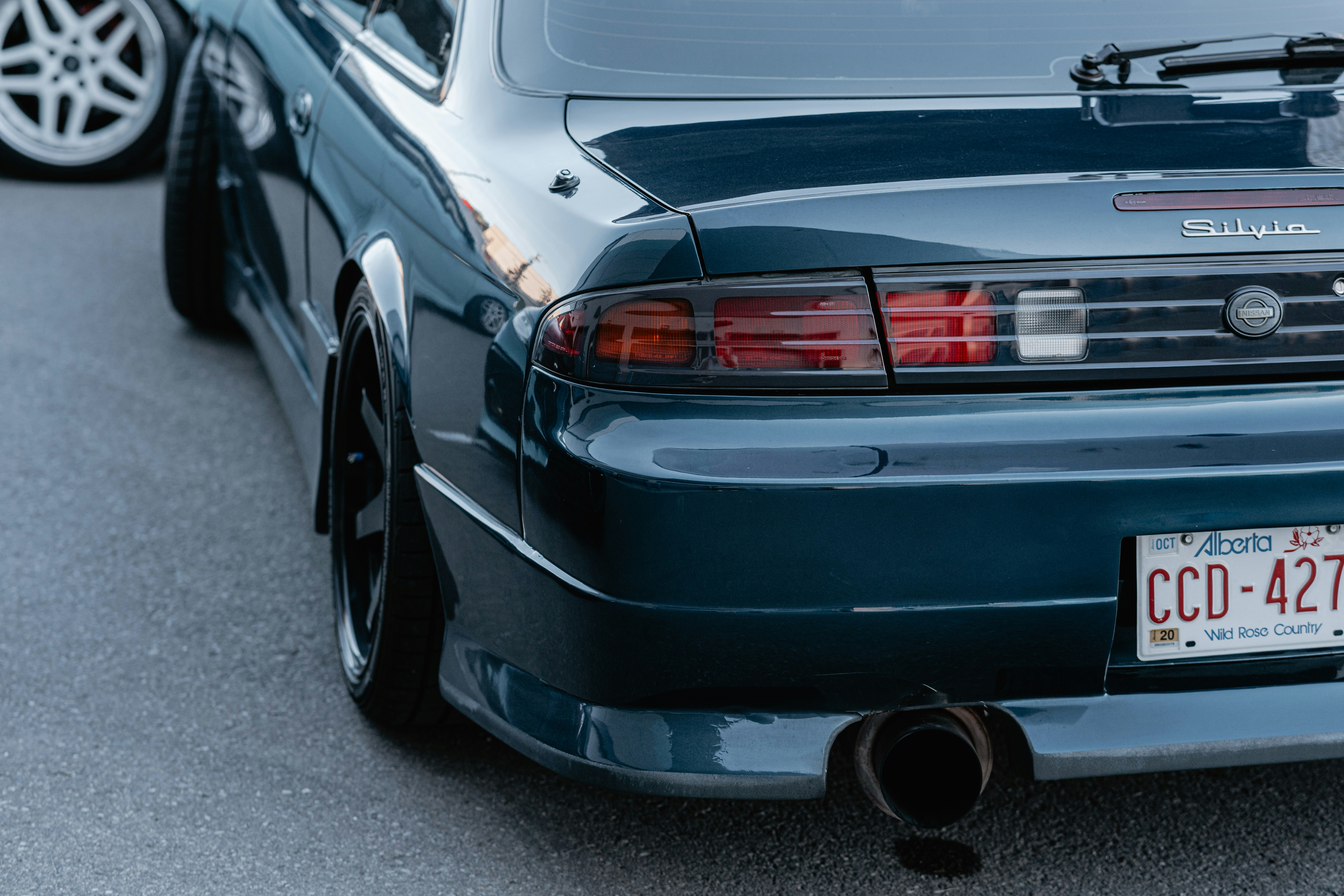 Rear-Quarters Reverie: A Stilled Moment of a Dulled Blue Coupe