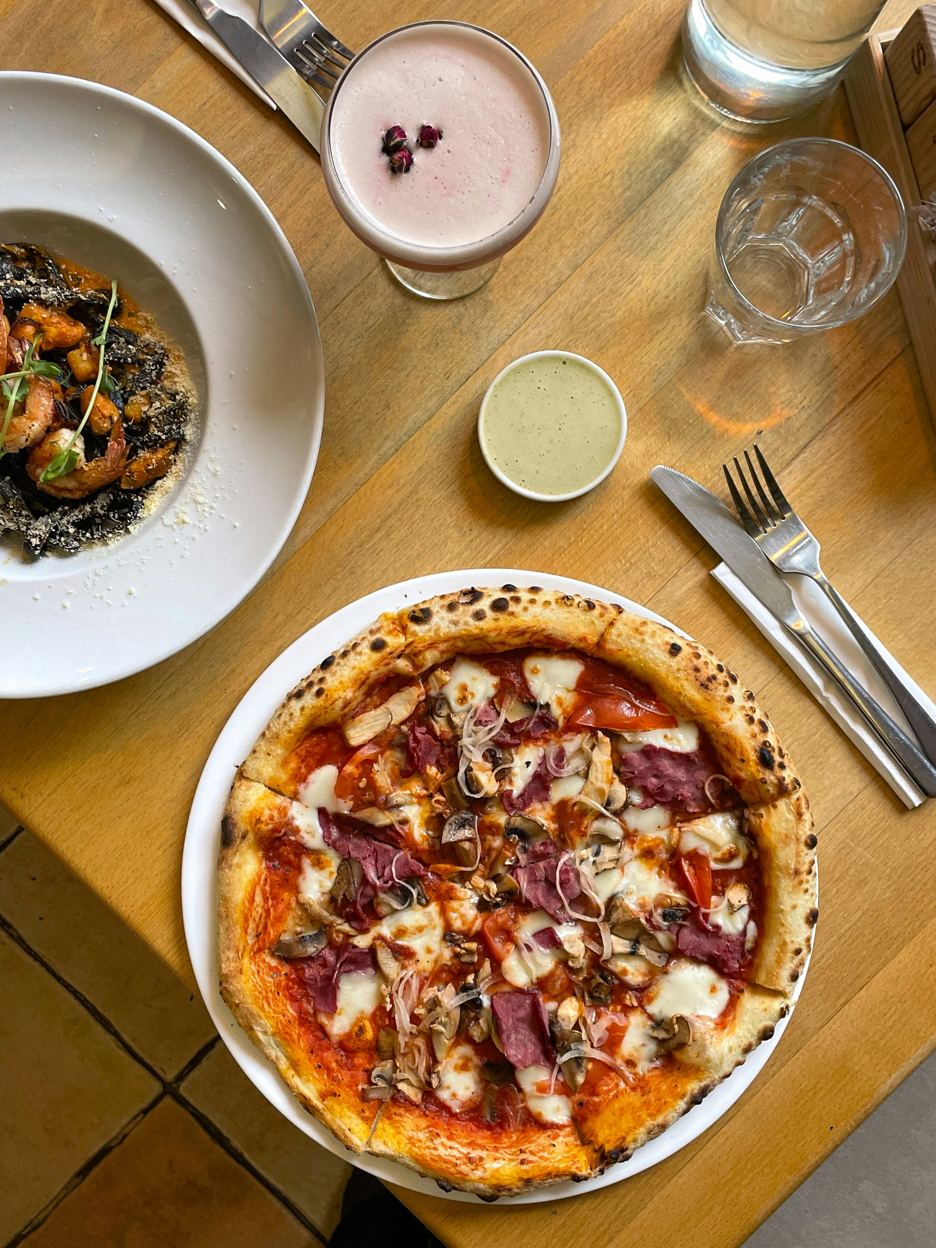 Fresh Italian Pizza and Cocktail on a Restaurant Table