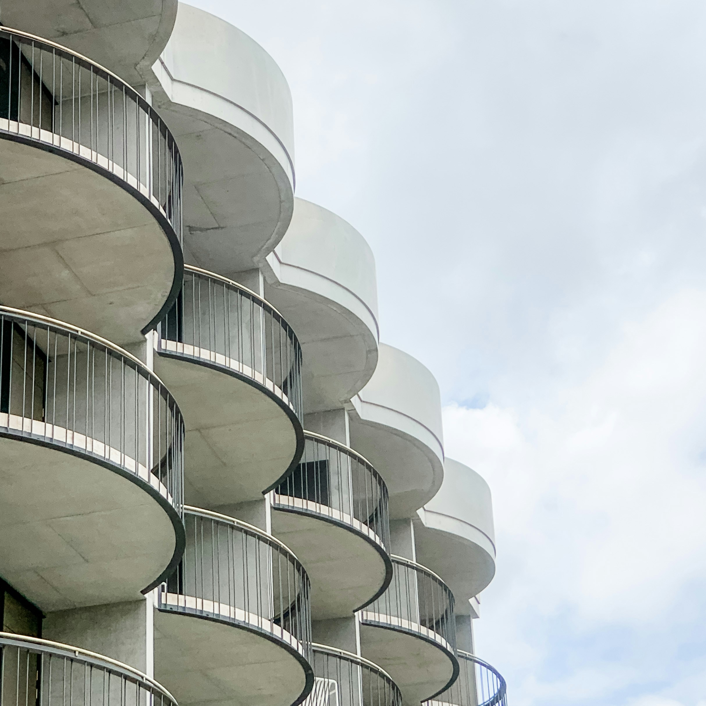 Row by Row: Circular Balconies Recede into a Sky of Soft Blue