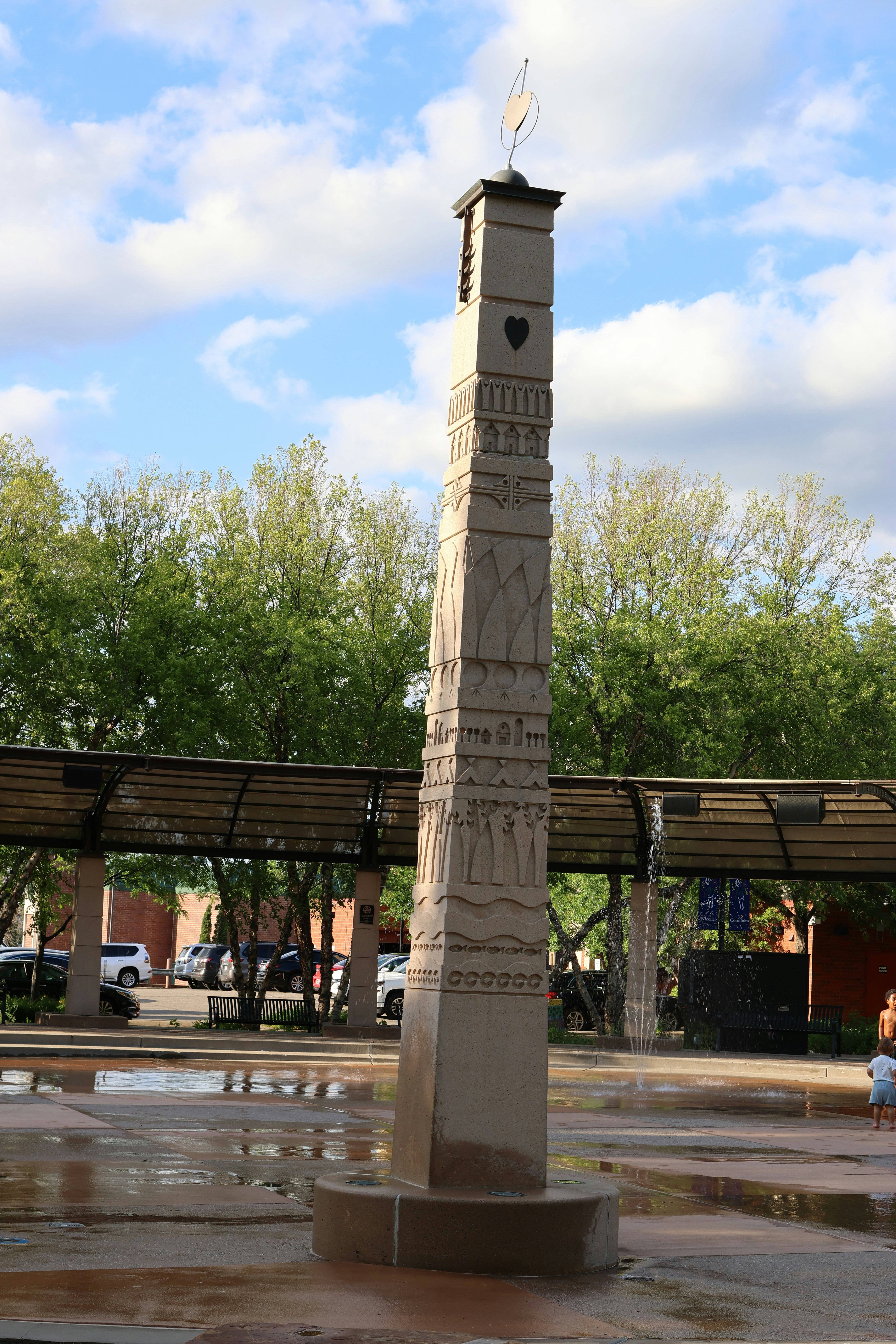 Stone Obelisk with Heart Carved Panel Under Bright Sky