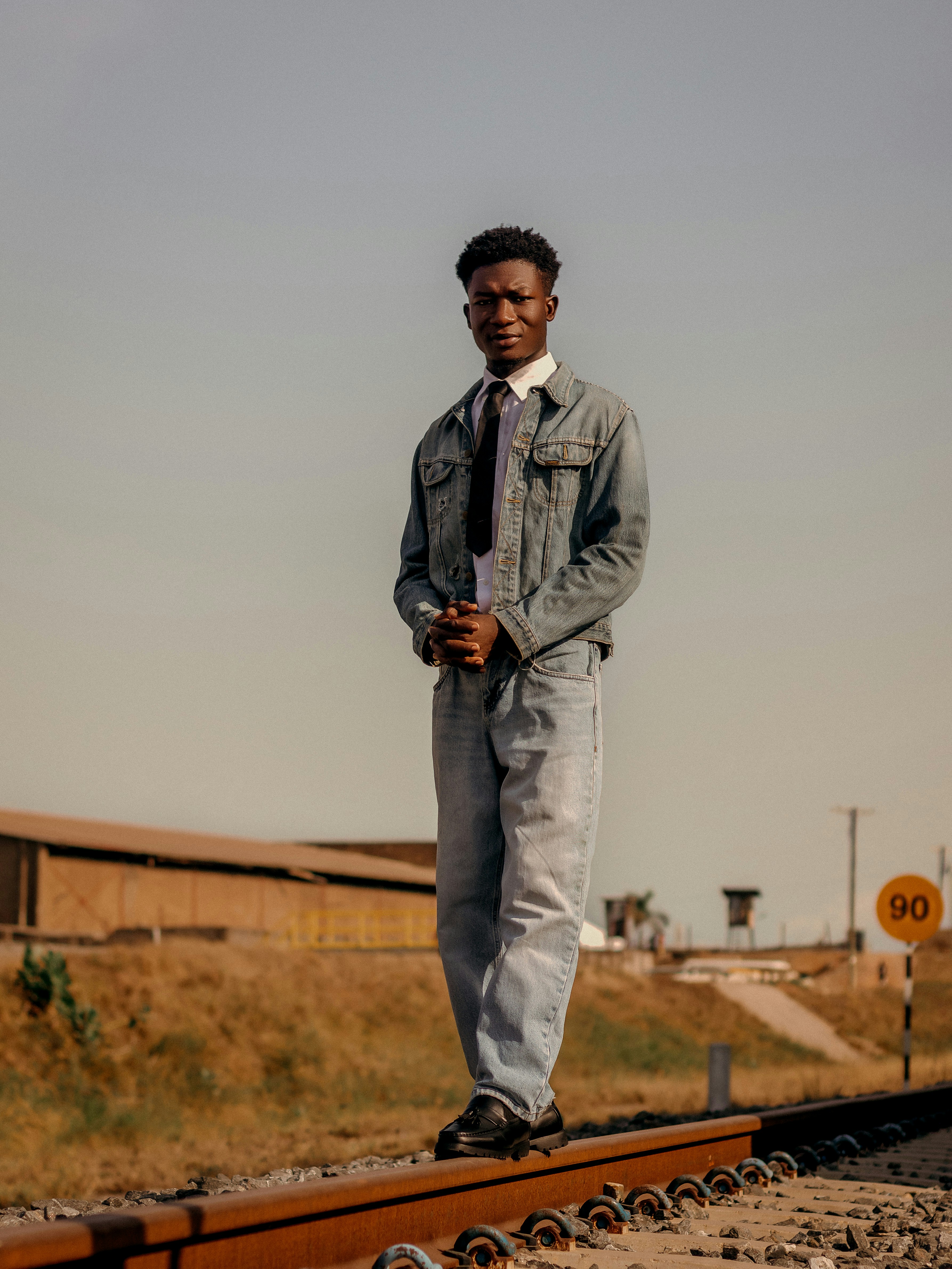 On the Rails: A Youthful Figure Balancing Above the Tracks