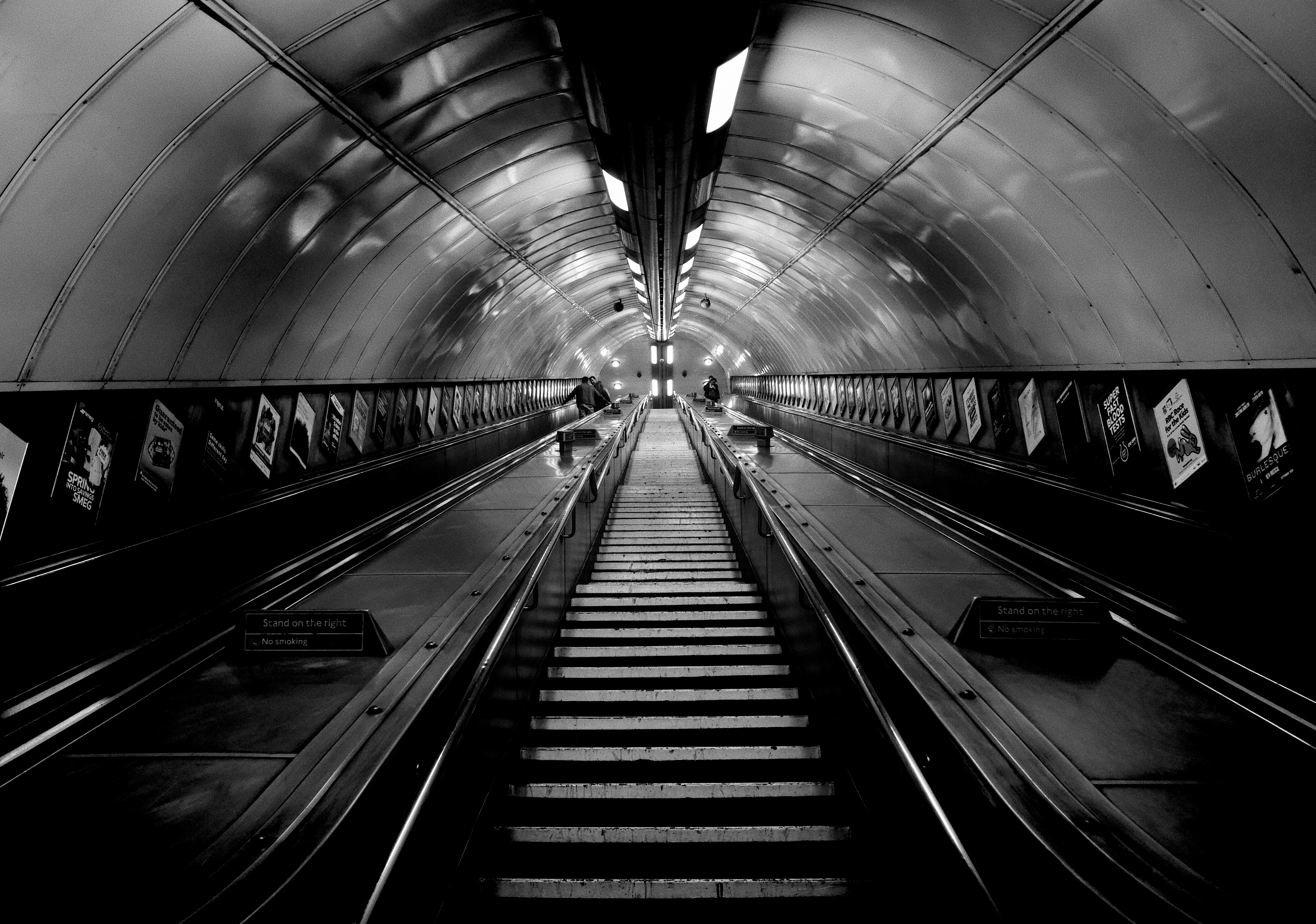 Centerline ascent: an empty subway stairs toward vanishing light