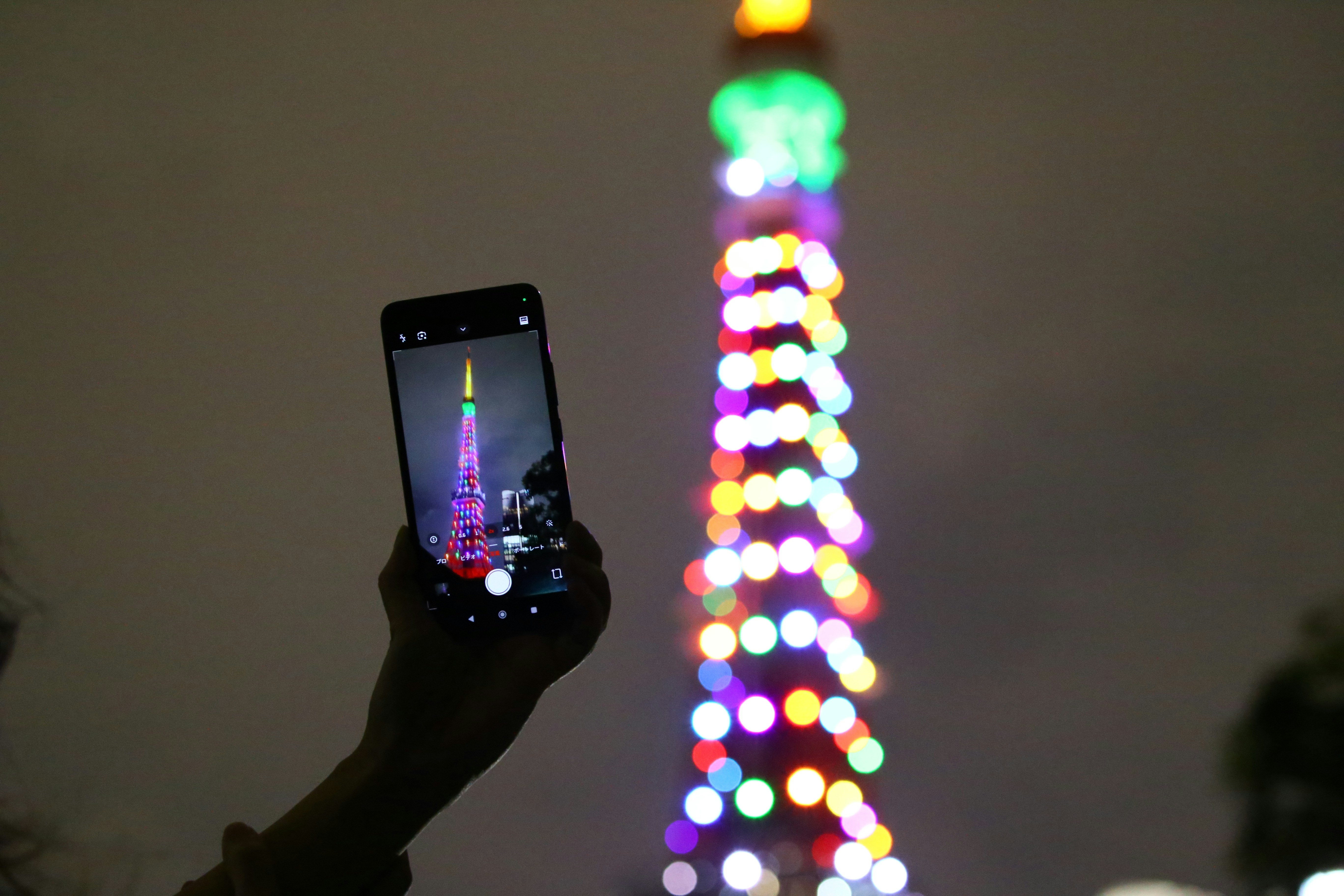 Capturing a Neon Tower: A smartphone framed by night lights